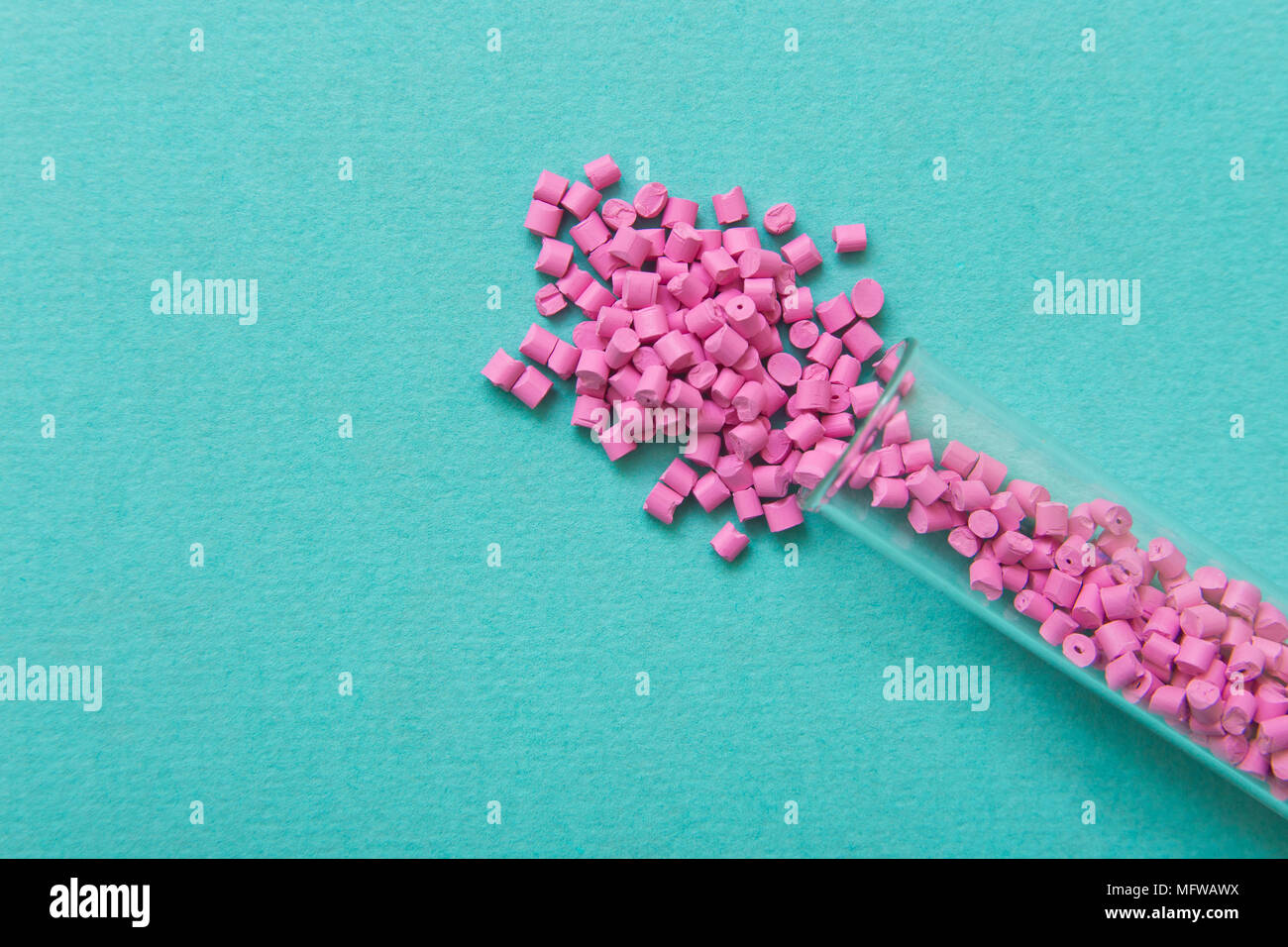 Plastic pellets. Pink Plastic granules on a turquoise background ...