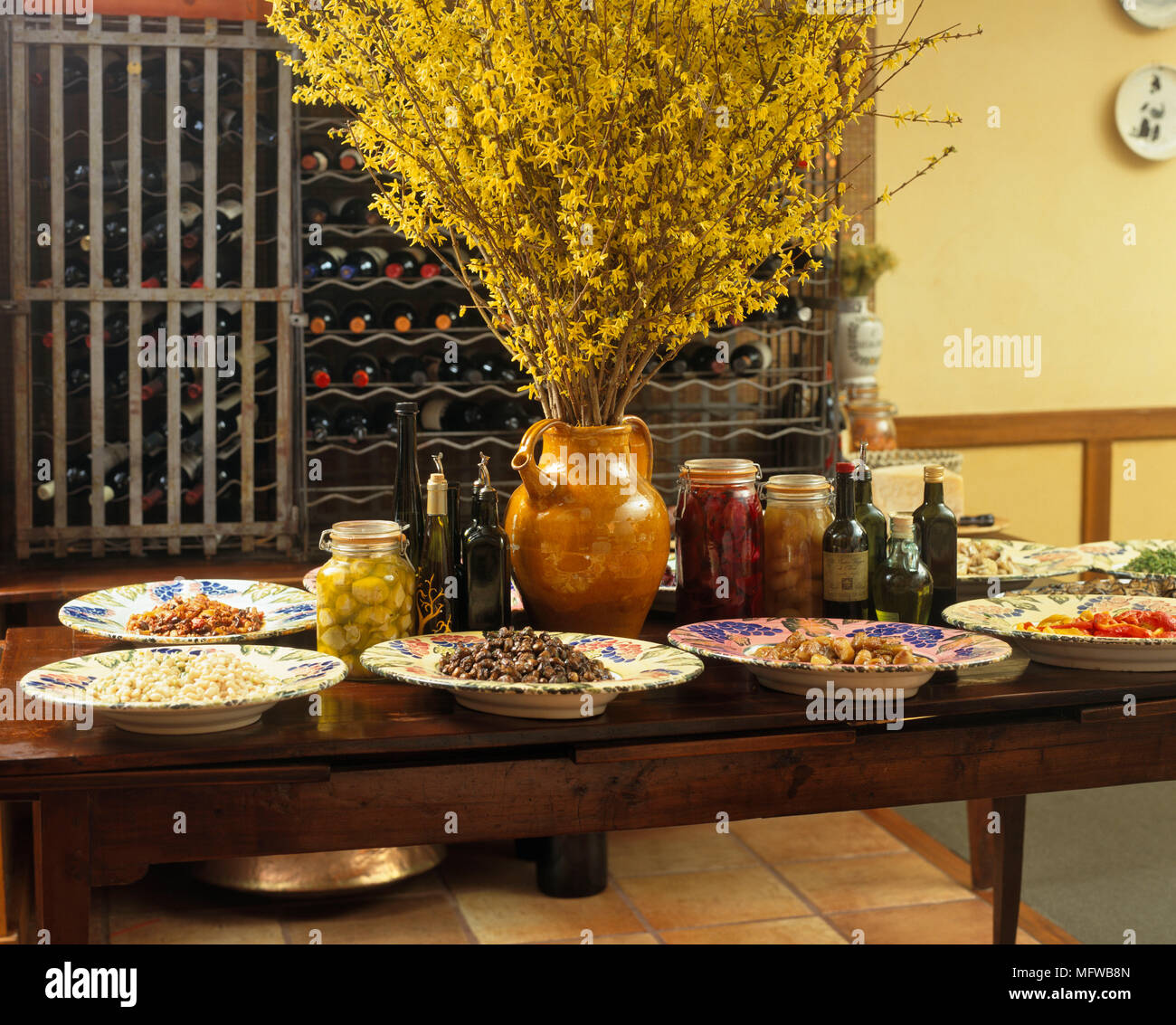 Plates of food laid out on table with jars and bottles Stock Photo - Alamy