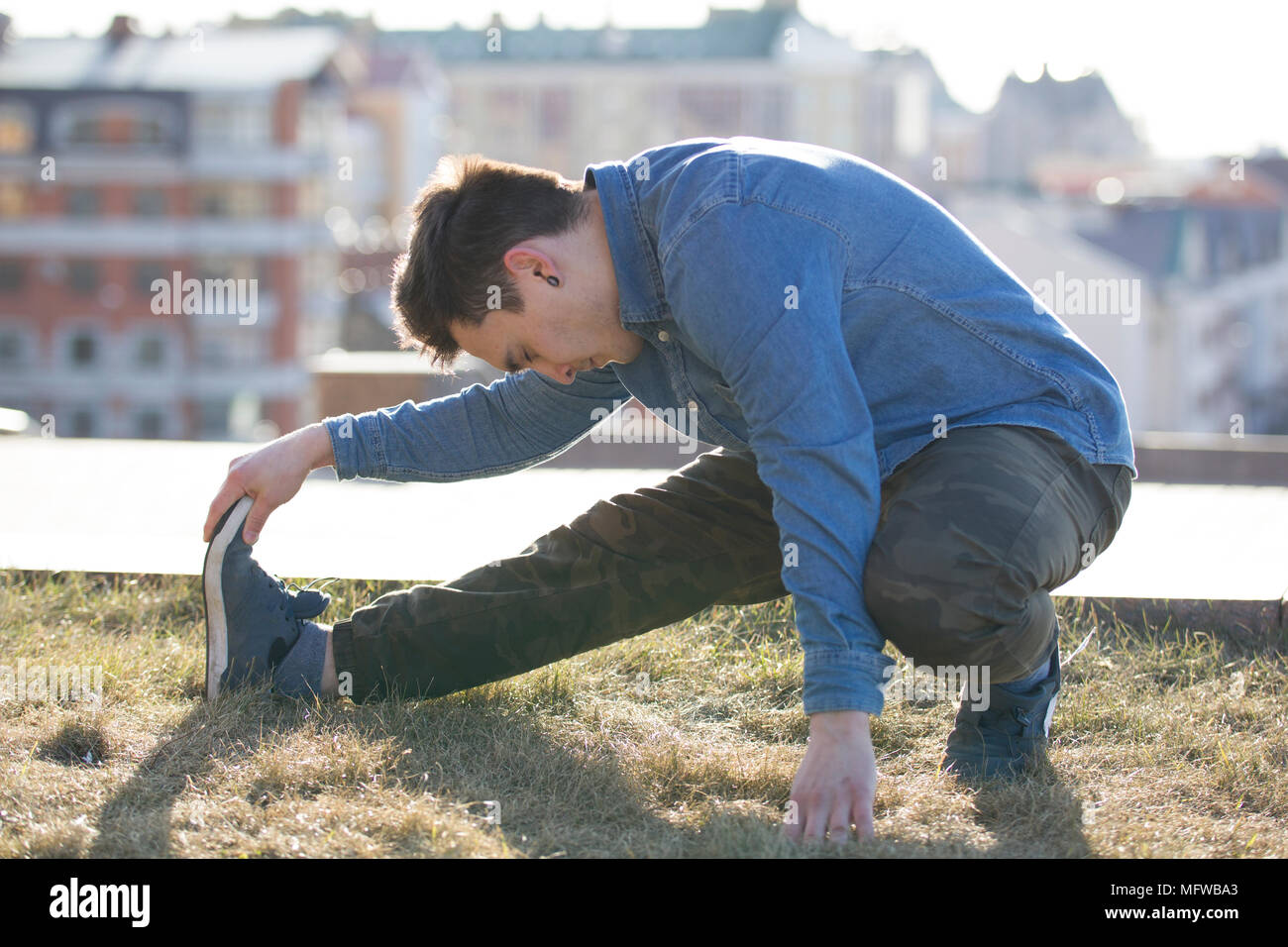 Young male parkour sportsman doing warm-up before acrobatic jumps in ...