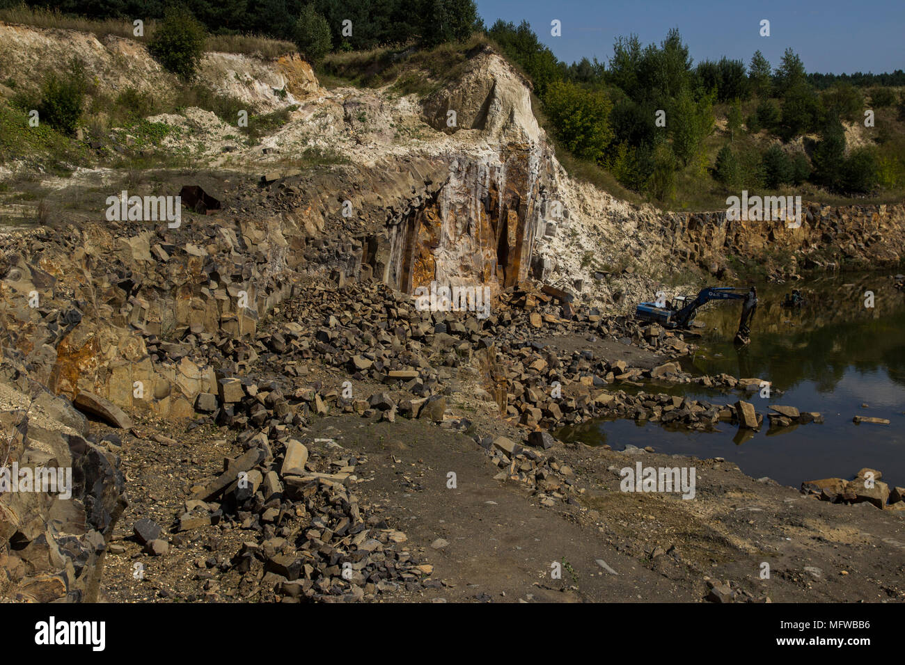 Basalt columns. Broken excavator and basalt columns rocks. Heavy ...
