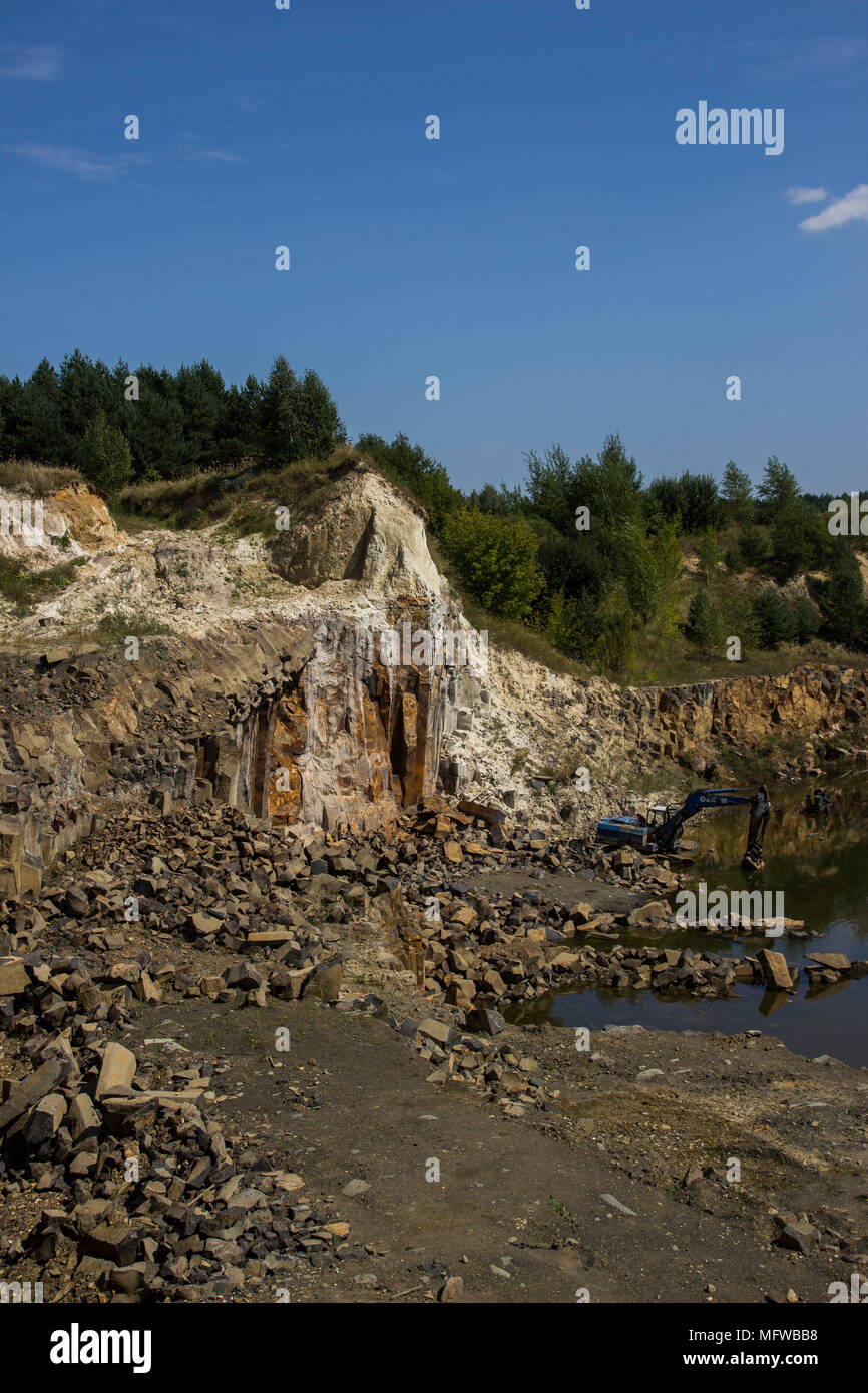 Basalt columns. Broken excavator and basalt columns rocks. Heavy ...