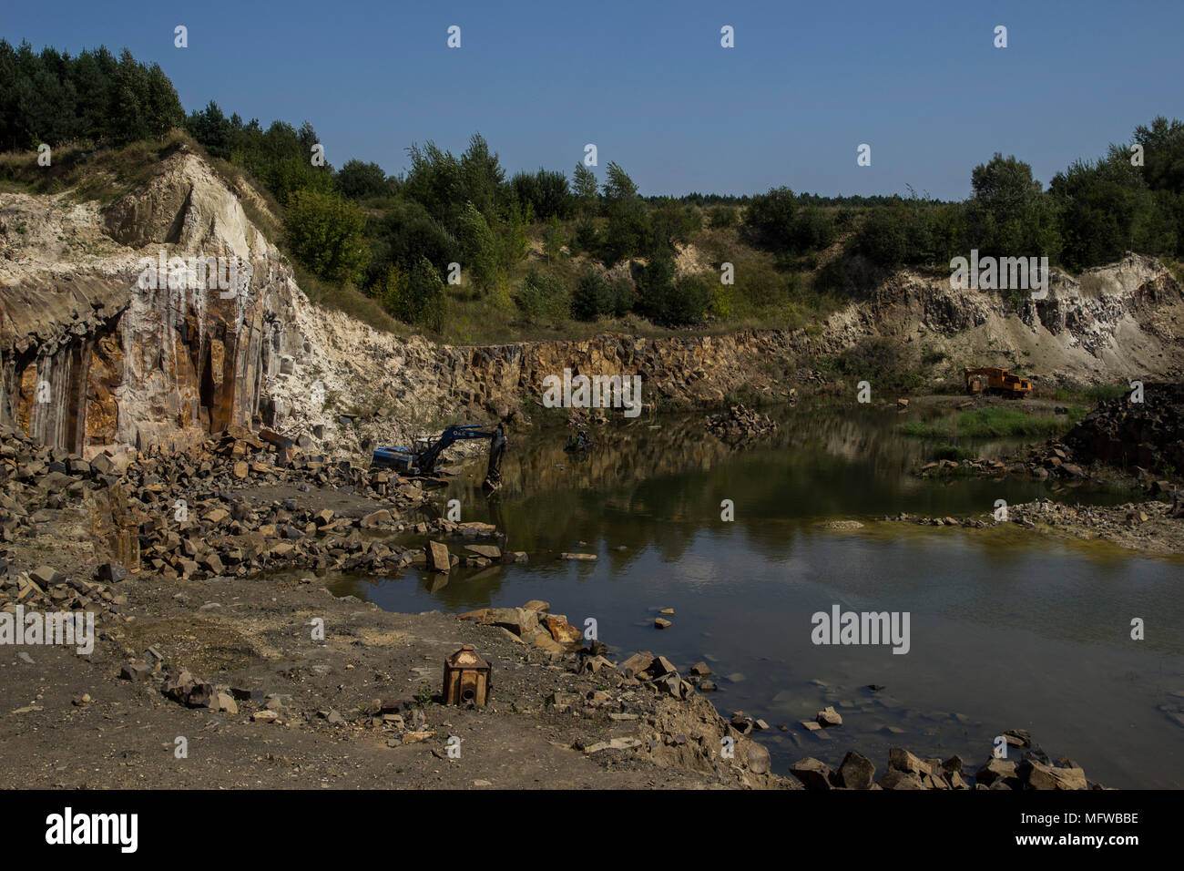 Basalt columns. Broken excavator and basalt columns rocks. Heavy ...