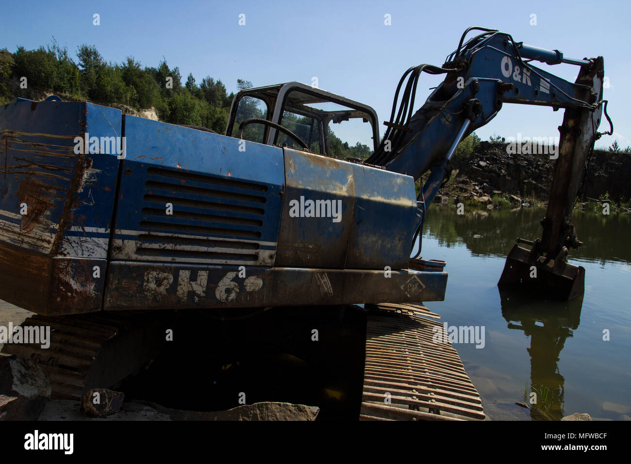 Broken excavator and basalt columns rocks. Heavy industry. Stone ...