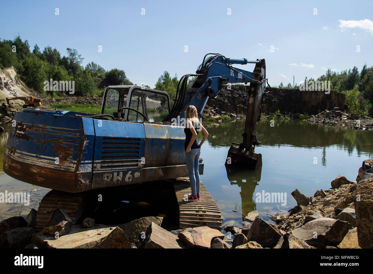 Broken excavator and basalt columns rocks. Heavy industry. Stone ...