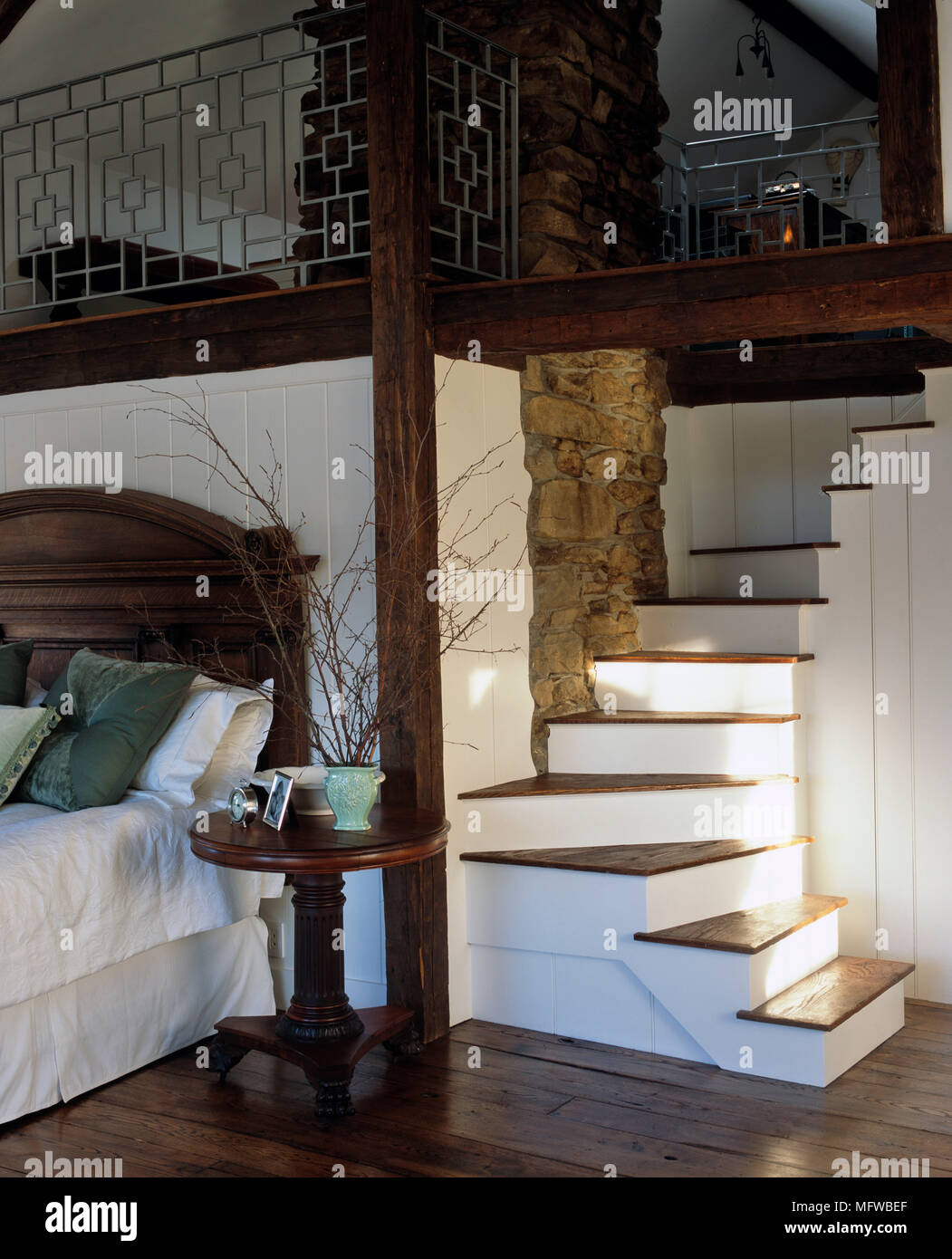 Staircase leading down to bedroom with double bed Stock Photo - Alamy