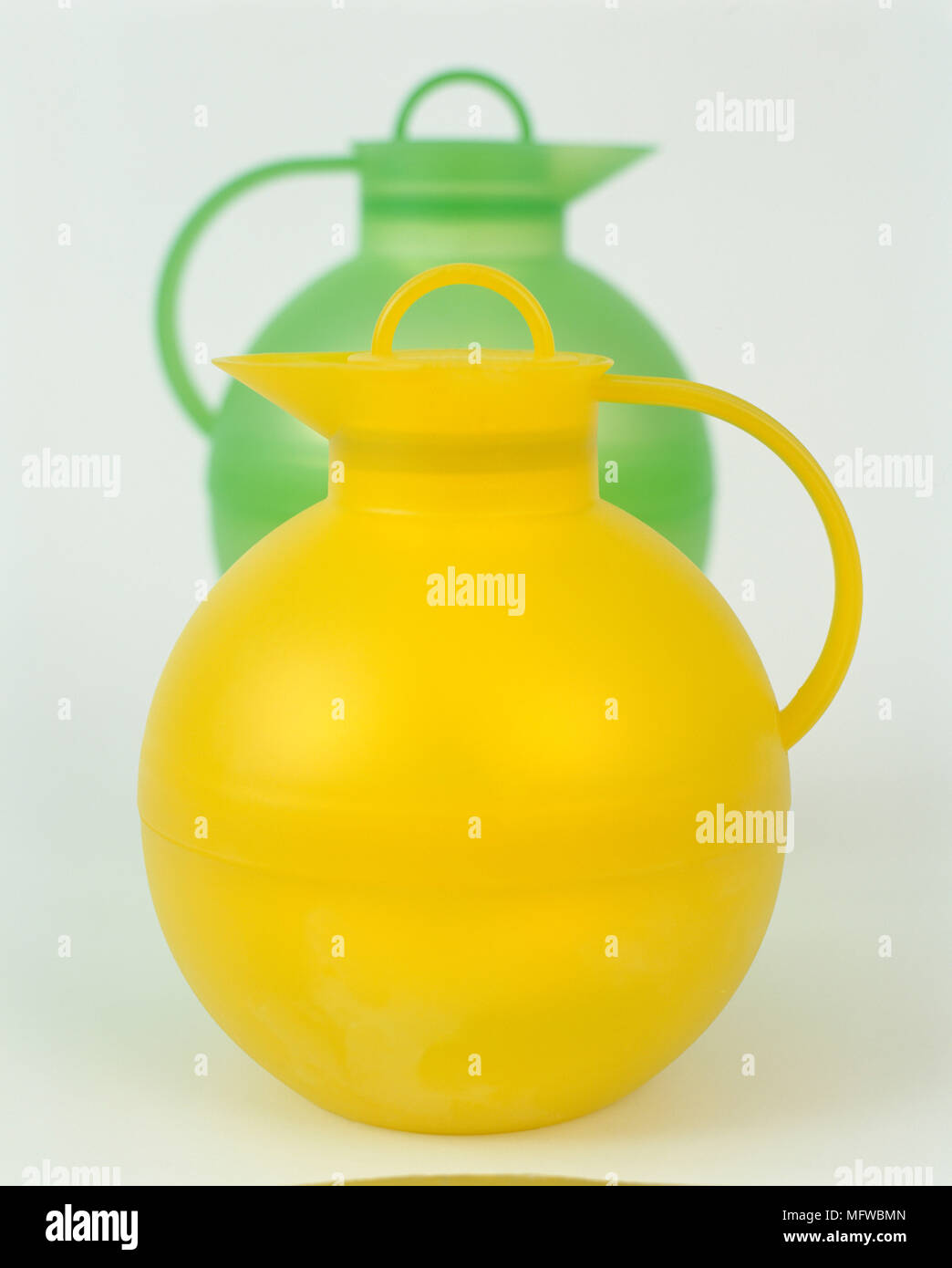 Two plastic jugs one yellow one green Stock Photo - Alamy
