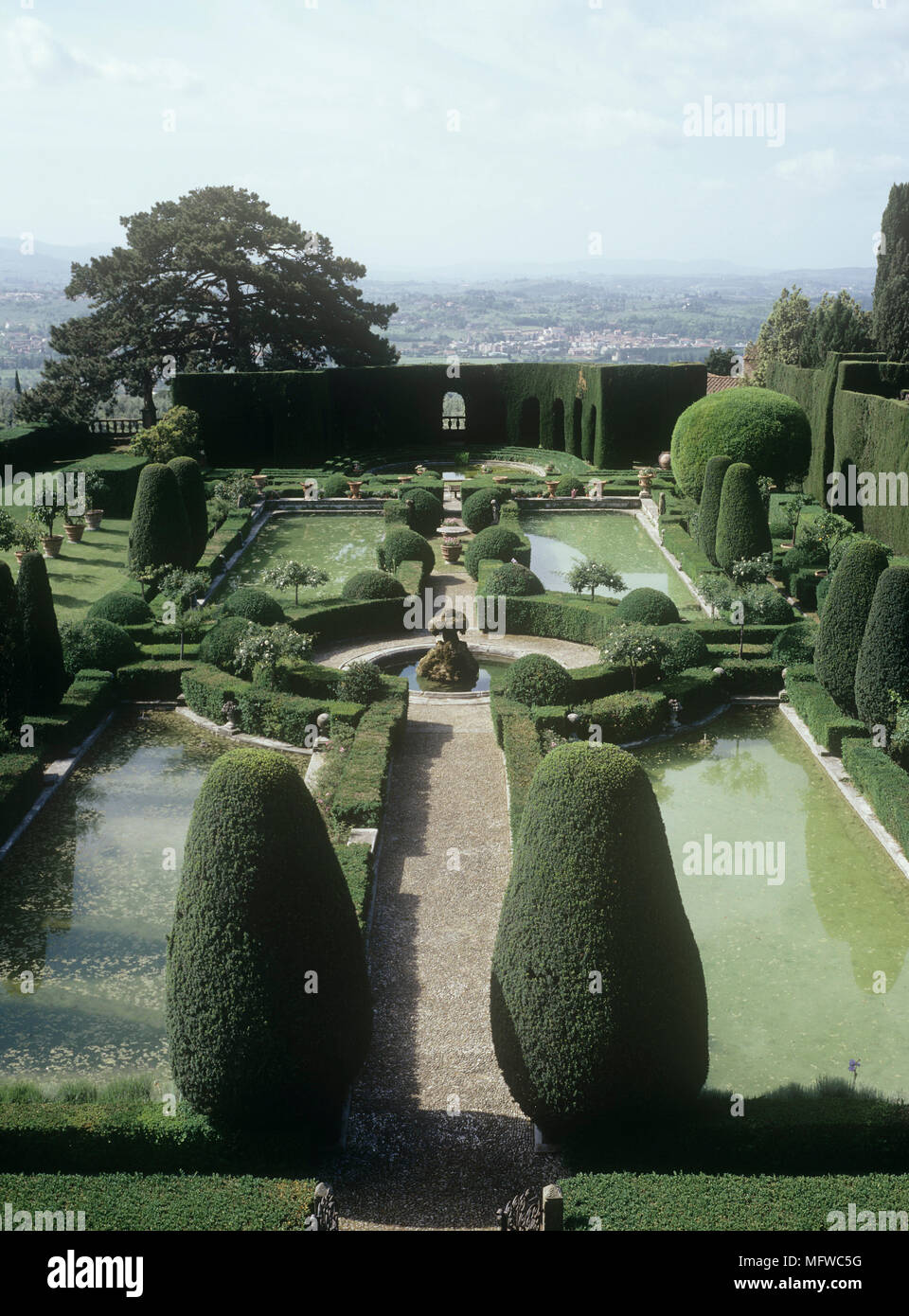 Formal garden with topiary and hedges dissected by a garden path and ...