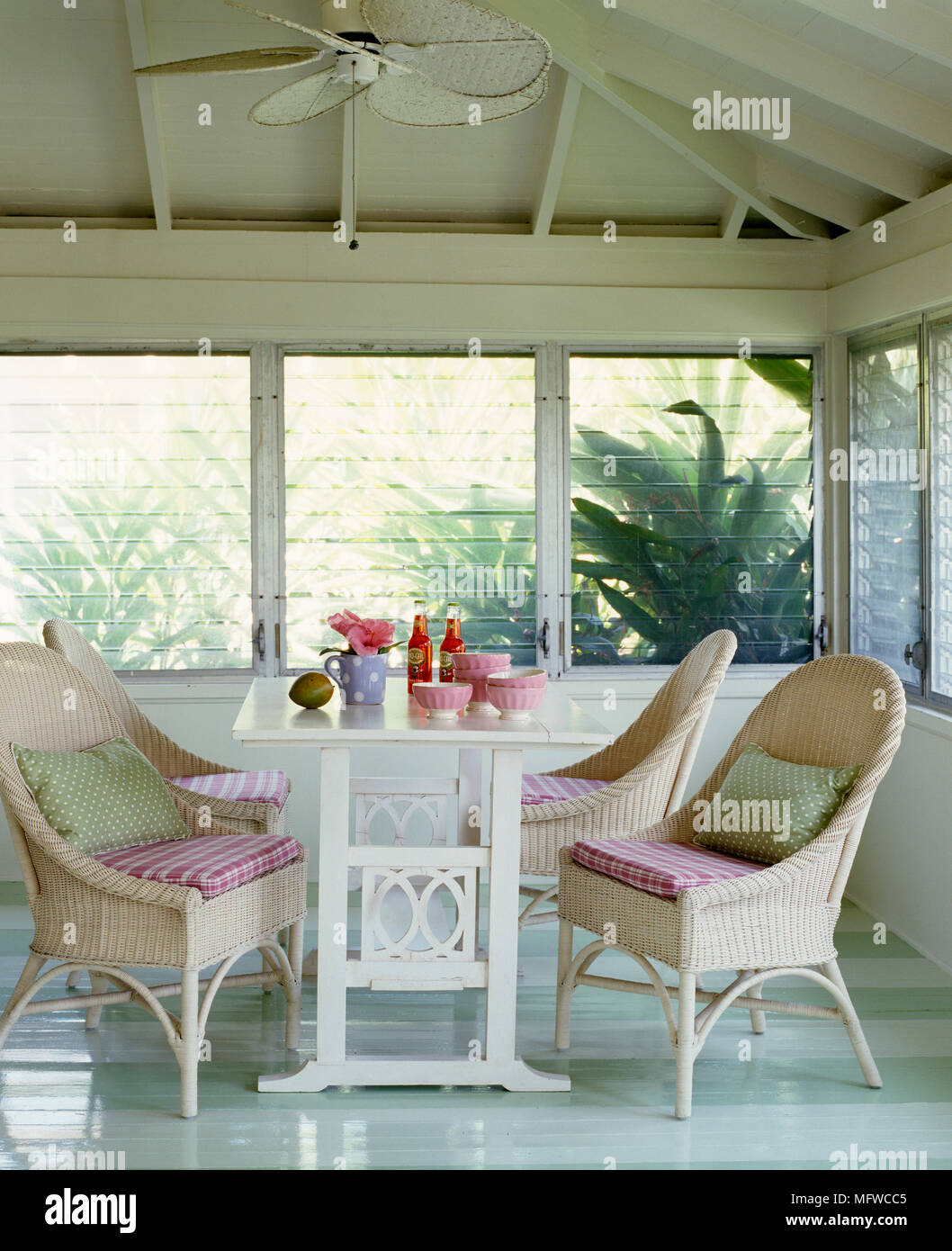 Cane furniture around white table in country style conservatory Stock ...