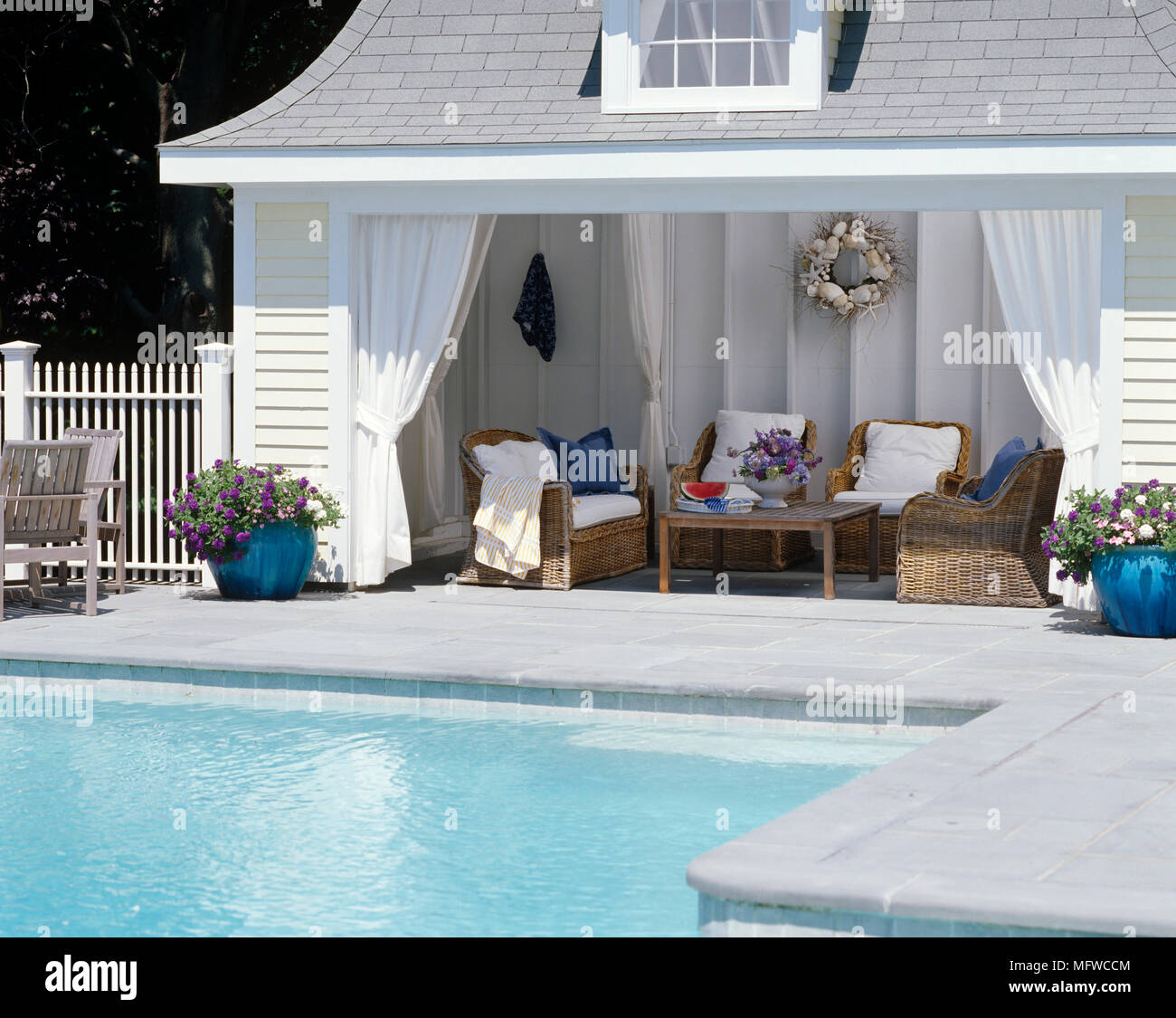 Cane seating beside swimming pool Stock Photo - Alamy