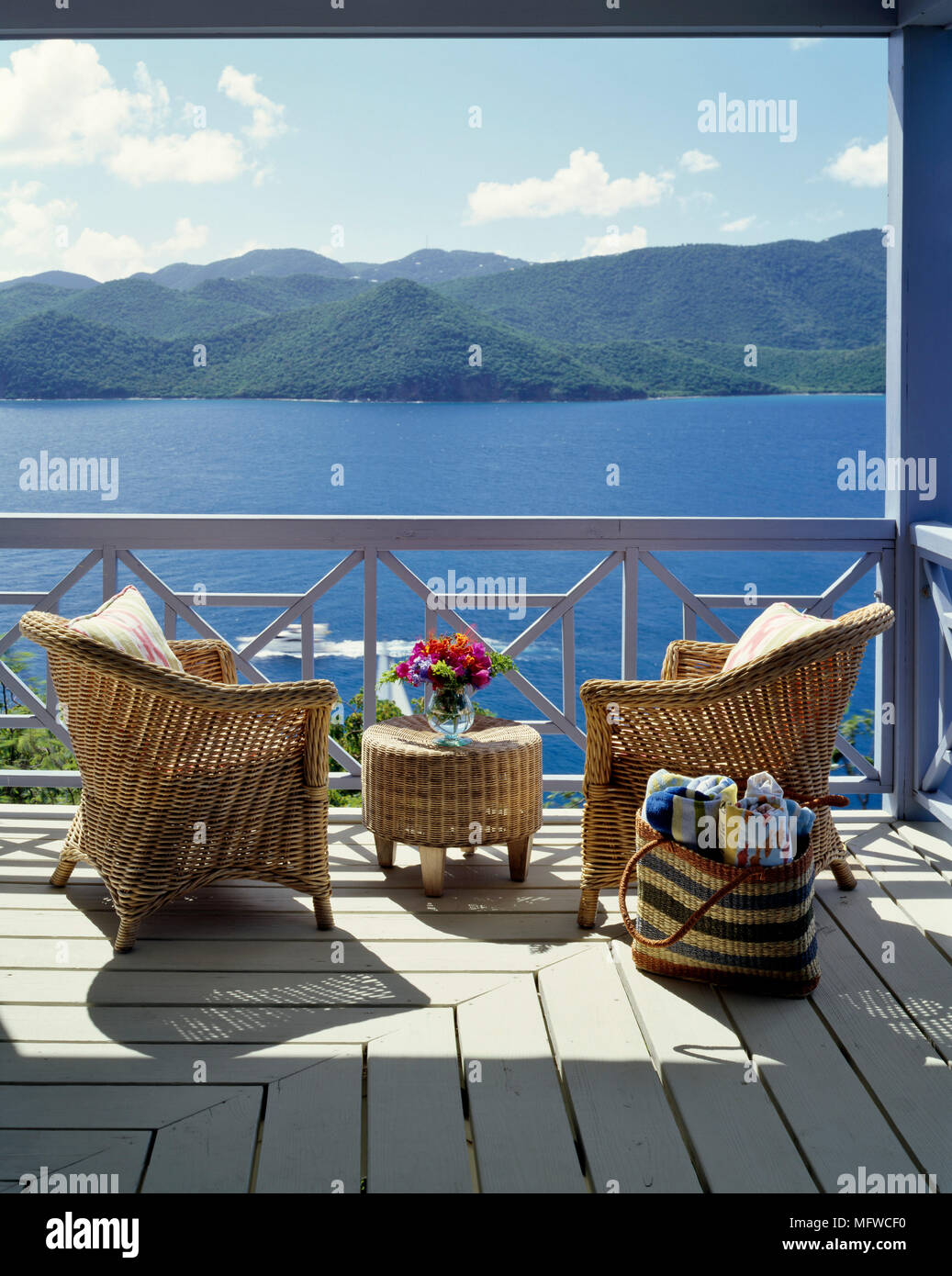 Cane chairs on veranda overlooking tropical island Stock Photo - Alamy