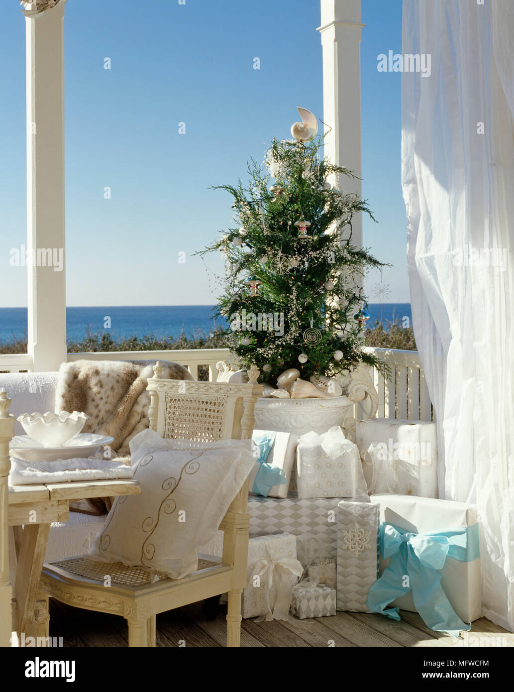 Christmas tree and gifts on veranda Stock Photo - Alamy