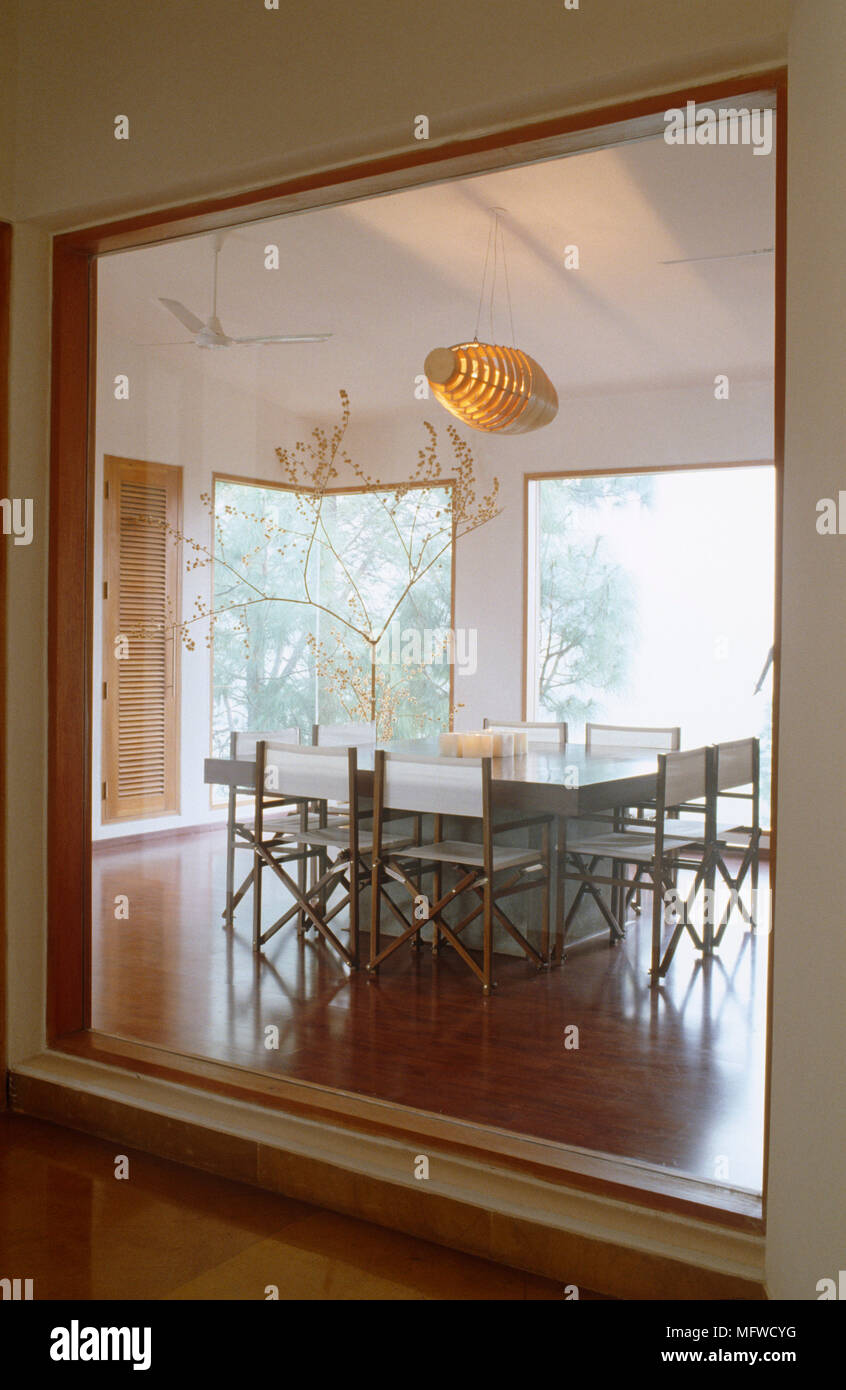 View through interior glass window to table and chairs in modern dining ...