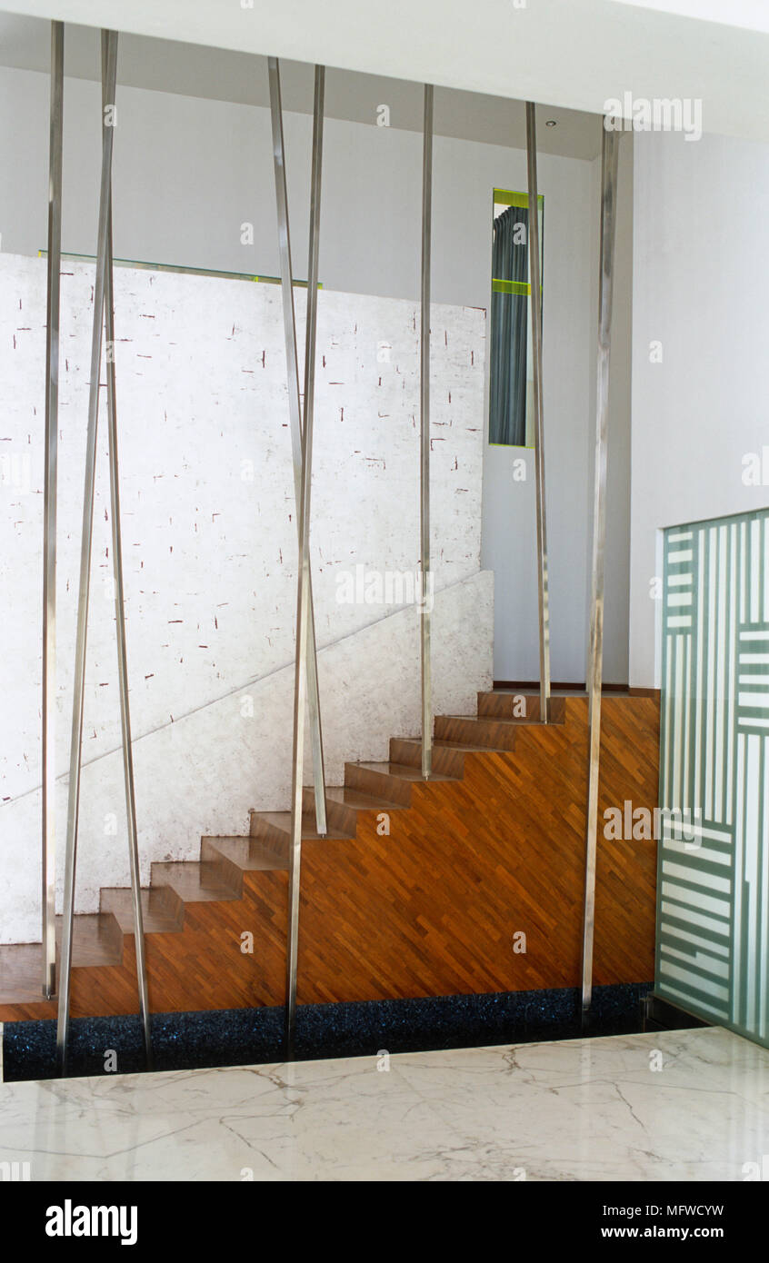 Modern wooden staircase with metal poles Stock Photo - Alamy