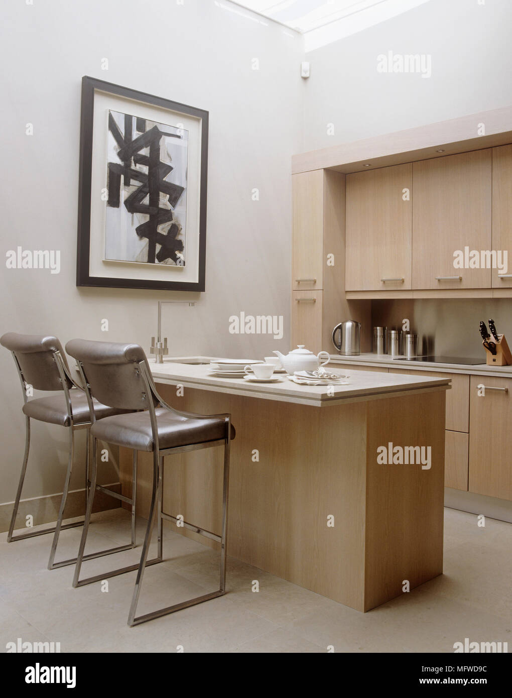 Two stools facing breakfast bar in kitchen with large skylight Stock ...
