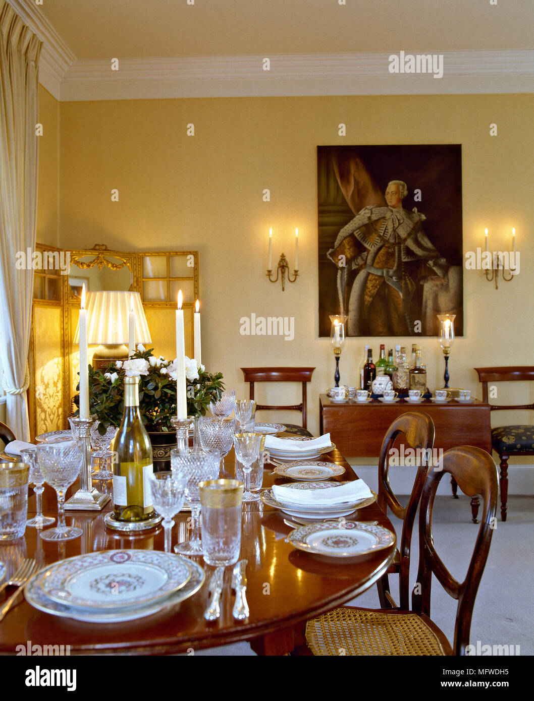 Yellow dining room with wood table and chairs, table setting Stock ...