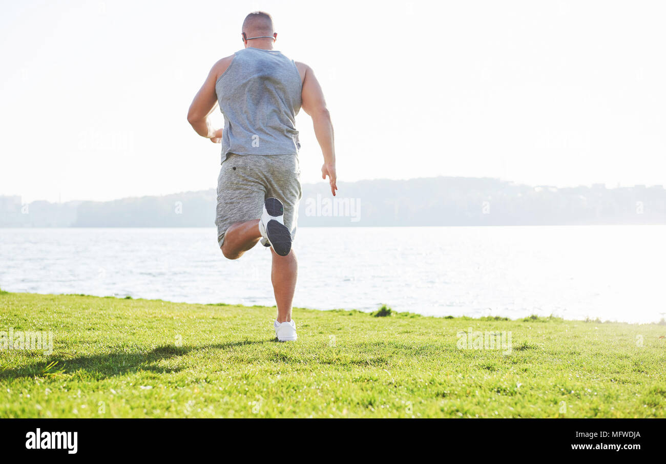 Fitness man athlete jogging in the nature during sunset. Person running ...
