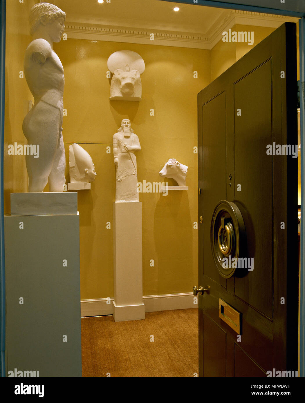 Collection of statues on plinths, open door to hallway Stock Photo - Alamy