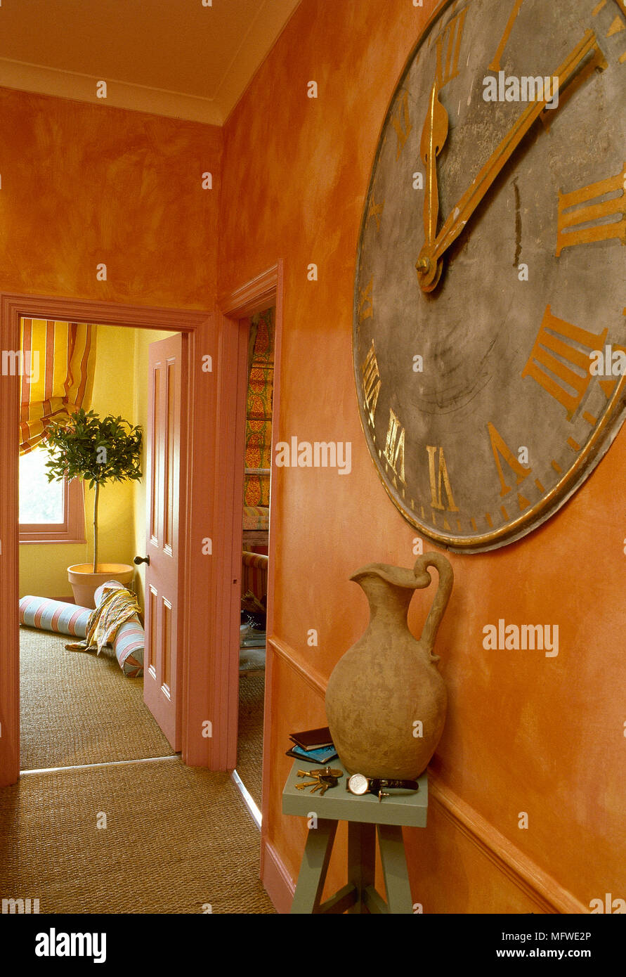 Terracotta hallway with large feature clock Stock Photo - Alamy