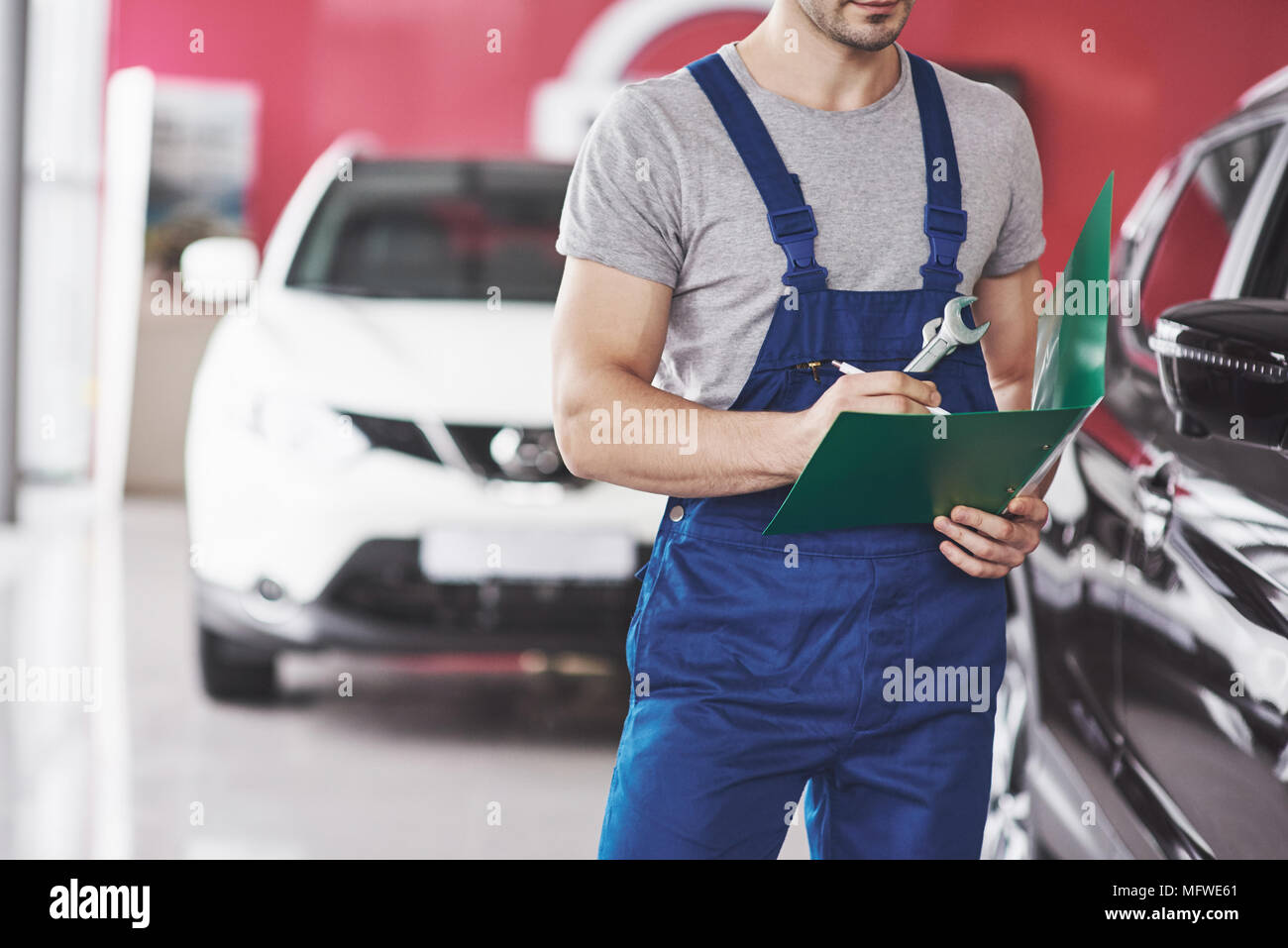 Hand of car mechanic with wrench. Auto repair garage Stock Photo - Alamy