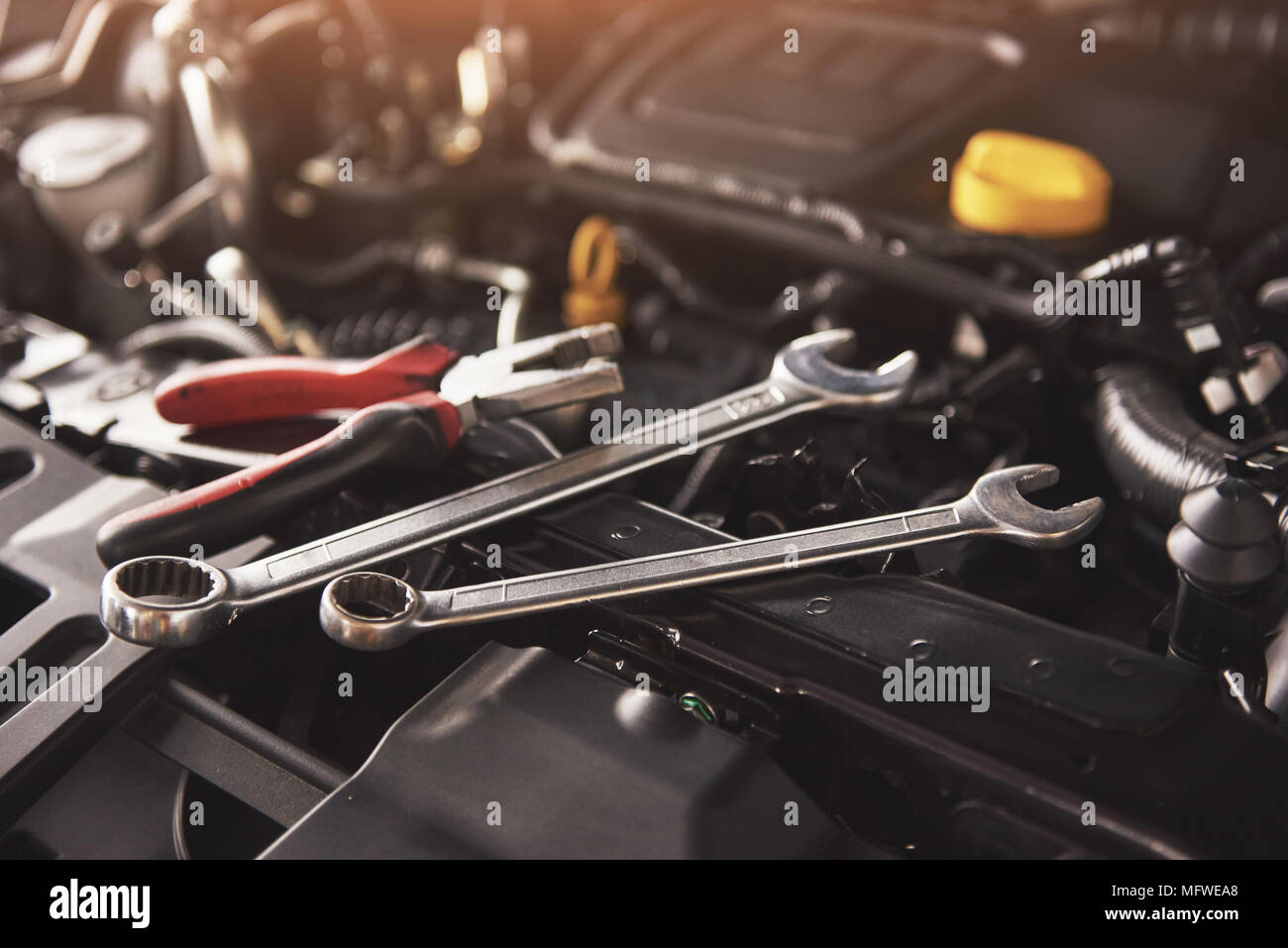 Mechanic hand checking and fixing a broken car in car service garage ...