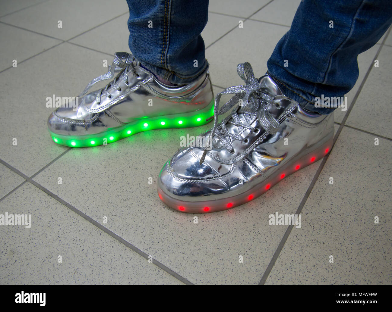 Fashionable sneakers with LED lighting on the legs of people Stock ...
