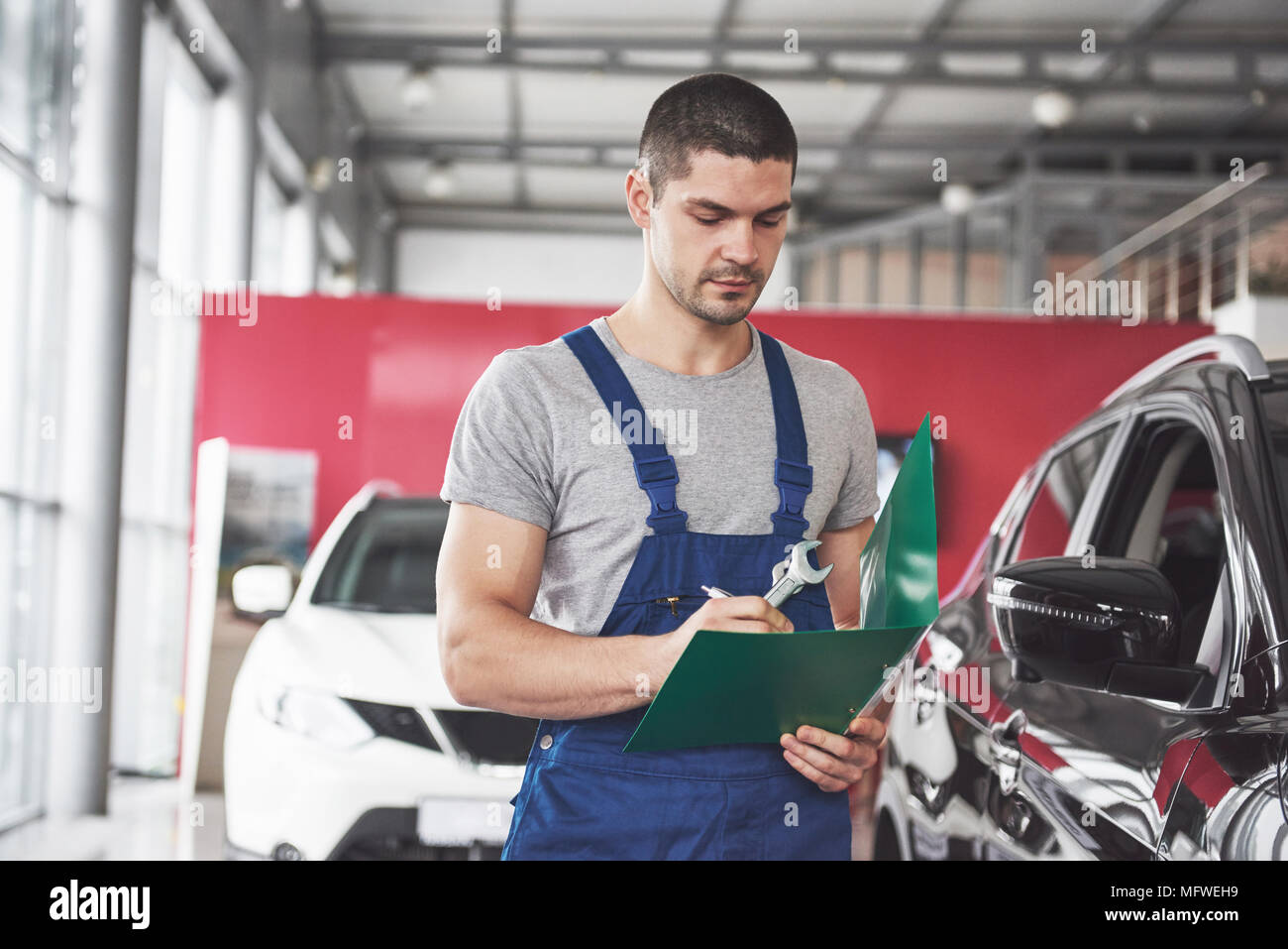 Portrait of a mechanic at work in his garage - car service, repair ...