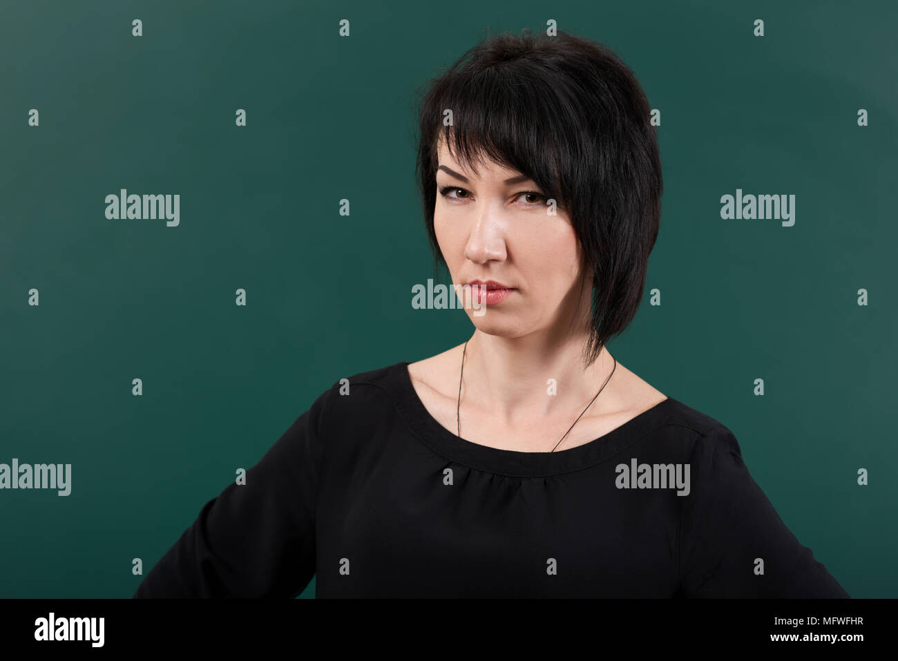 strict girl teacher posing by chalk Board, learning concept, green ...