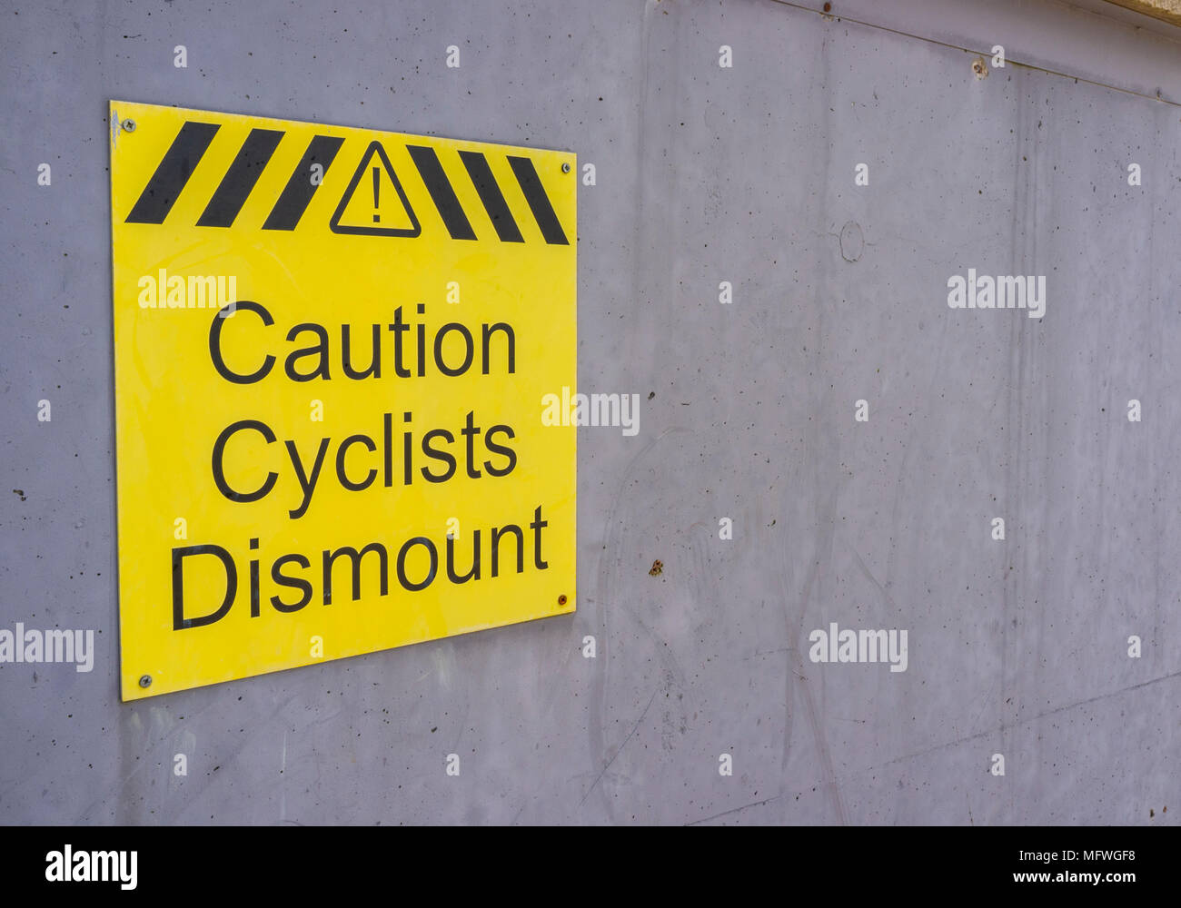 Caution Cyclists Dismount sign on wall Stock Photo - Alamy