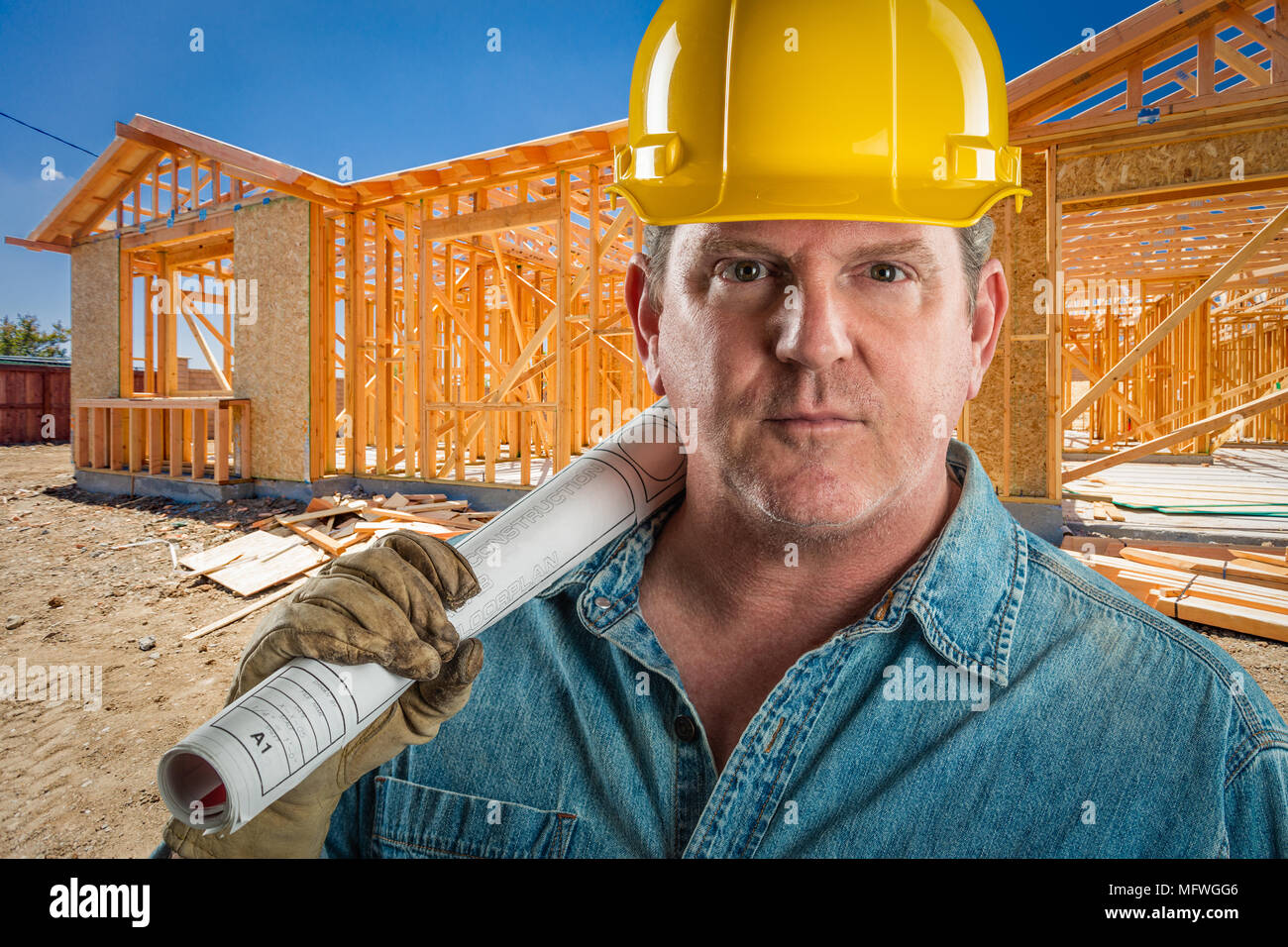 Serious Contractor in Hard Hat Holding Floor Plans At Construction Site ...