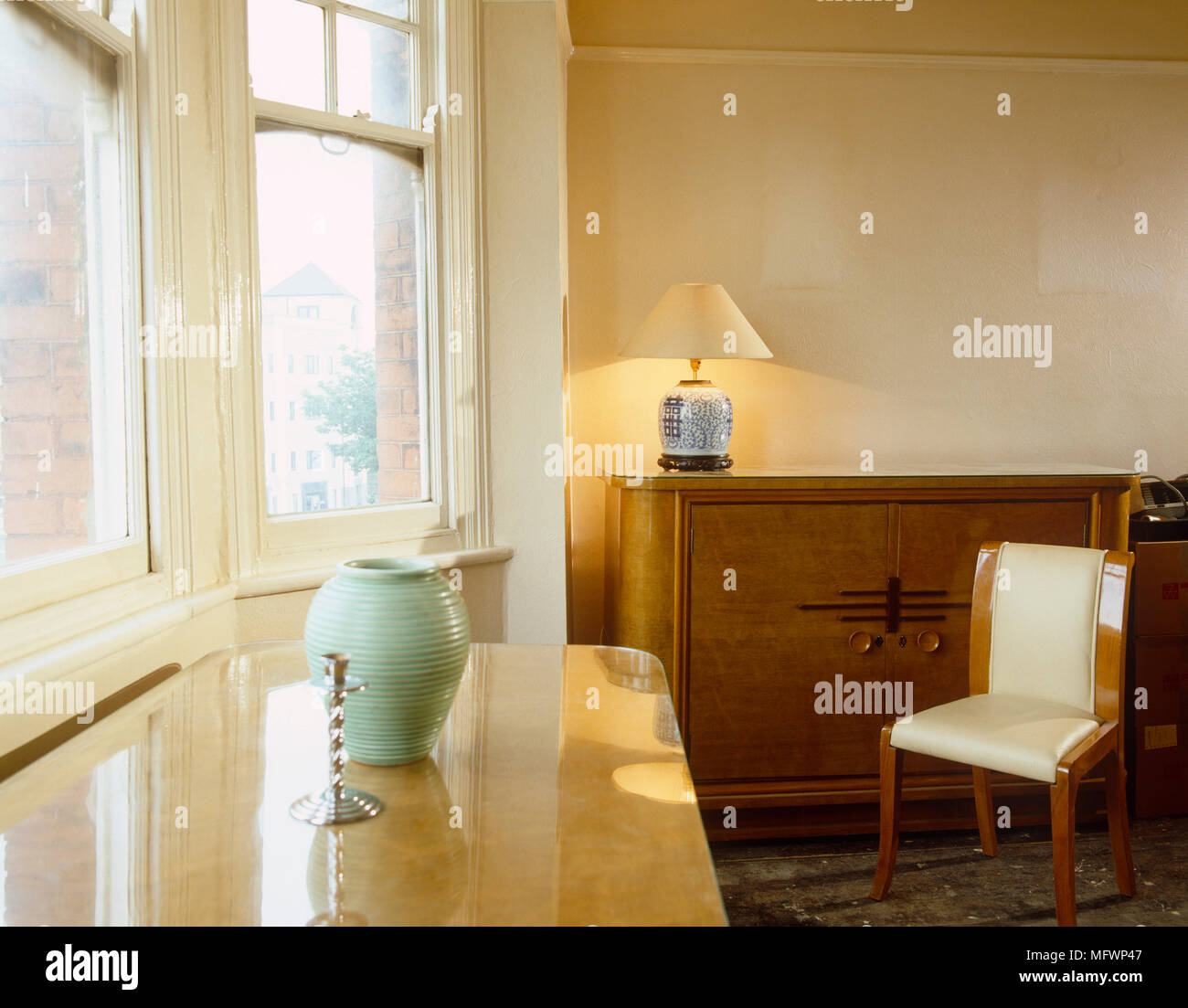 Pottery vase and candlestick on polished wood table in bay window Stock ...