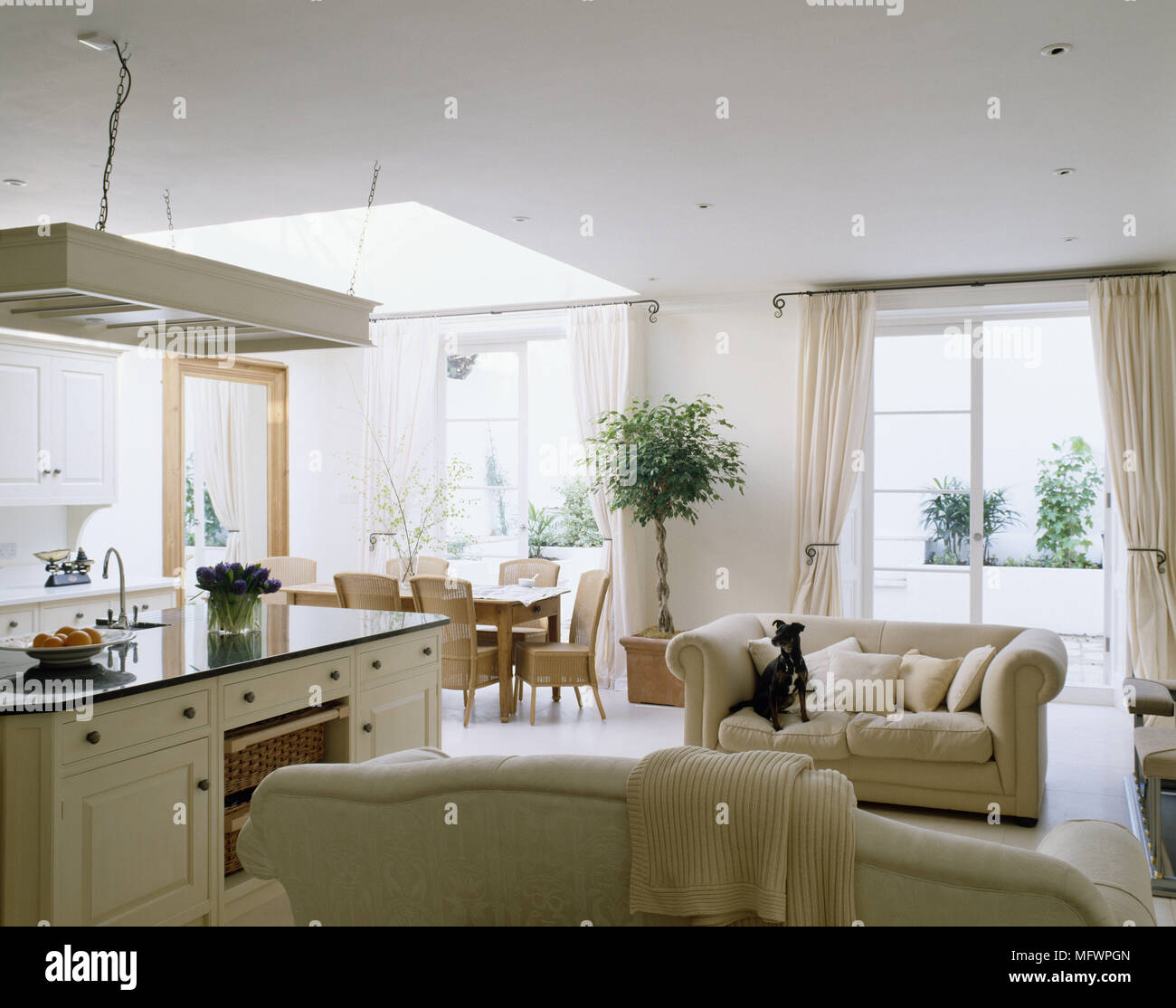 Open plan kitchen with dining and sitting area with pair of sofas Stock ...