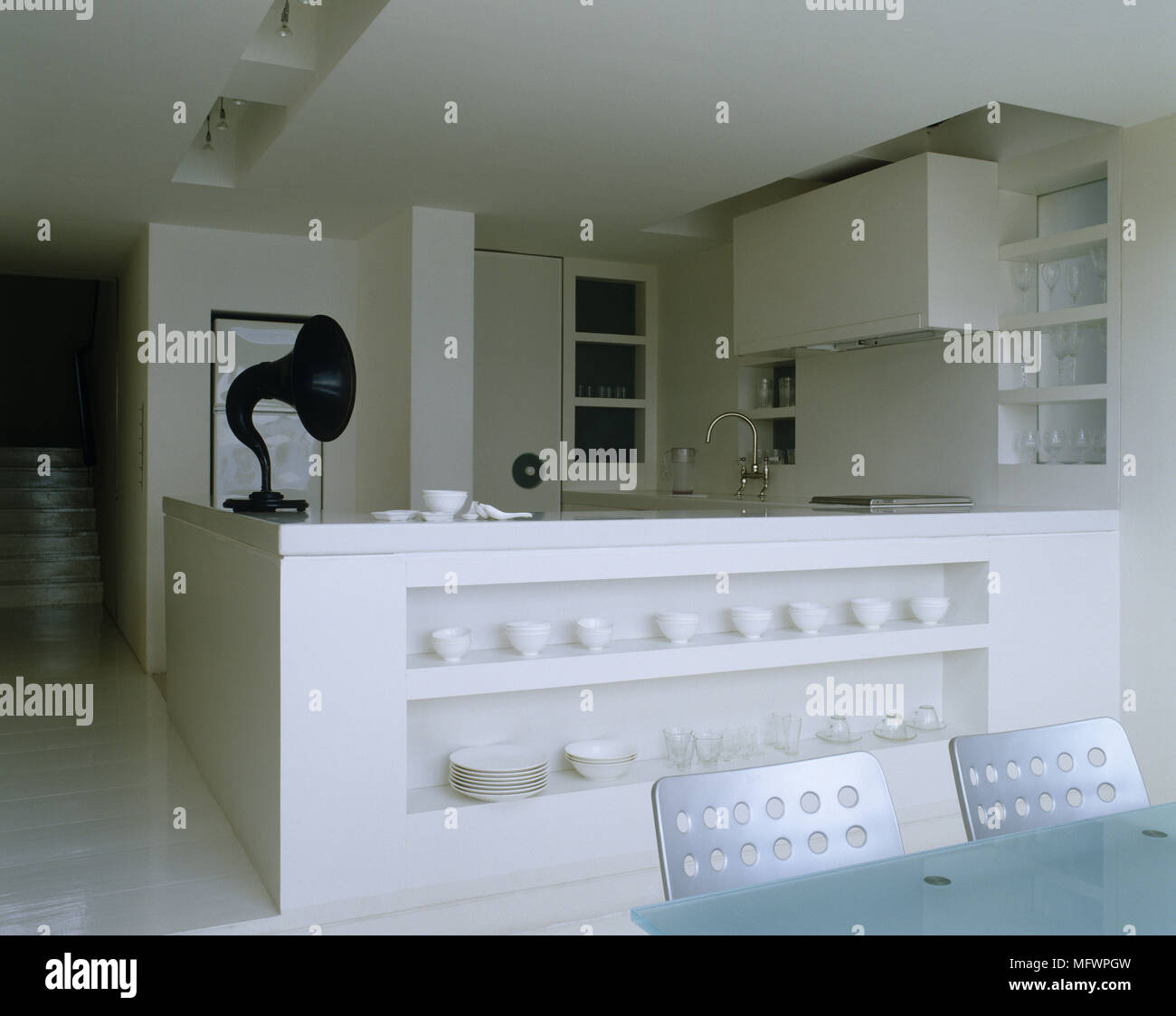 Open plan kitchen with dining area with blue glass topped table Stock ...