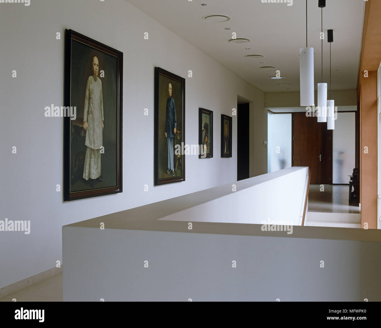 Portrait artworks lining walls of hallway Stock Photo - Alamy