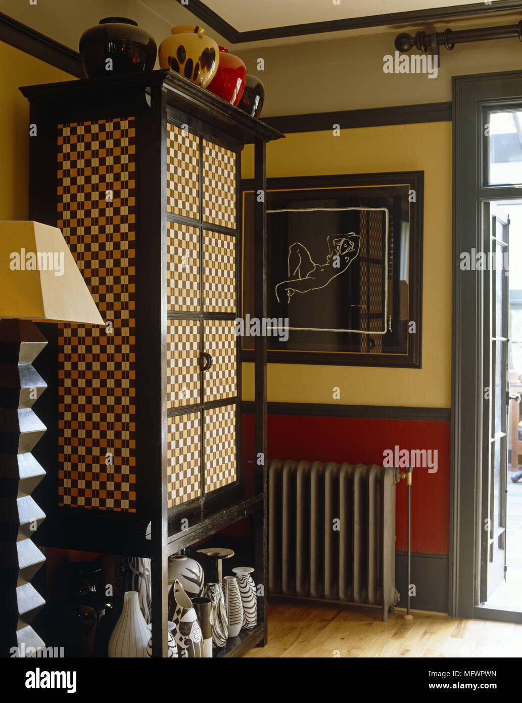 Cupboard painted with check pattern next to frame artwork above retro ...