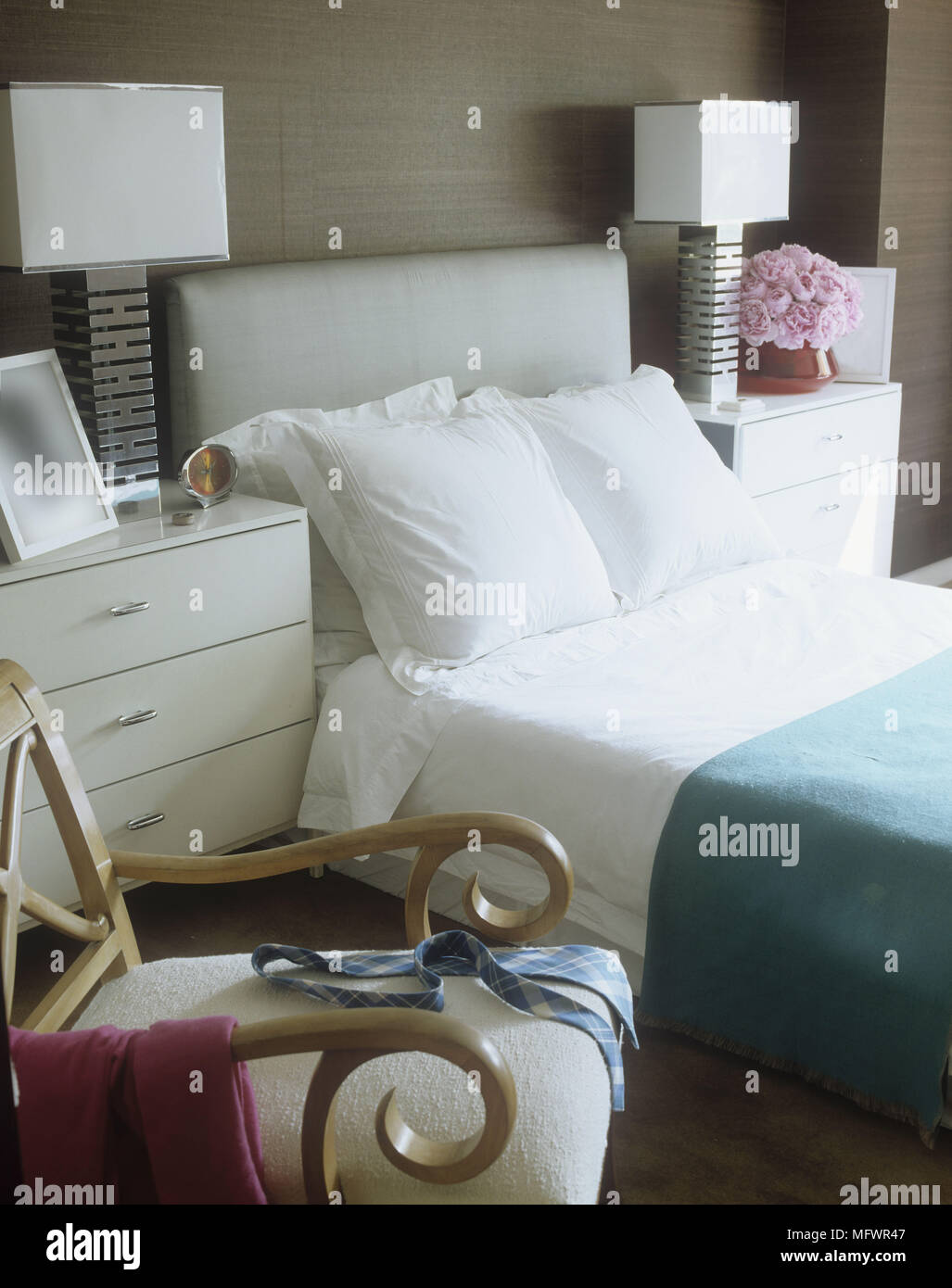 Double bed in bedroom with bedside table and chair Stock Photo - Alamy