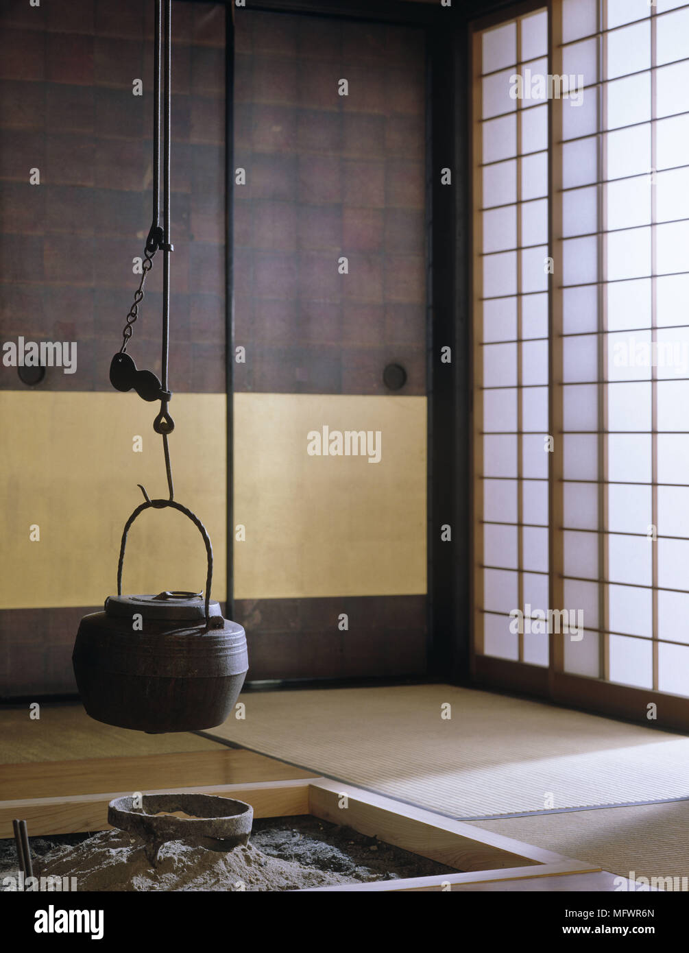 Cooking pot suspended over open fire in Japanese style room with ...