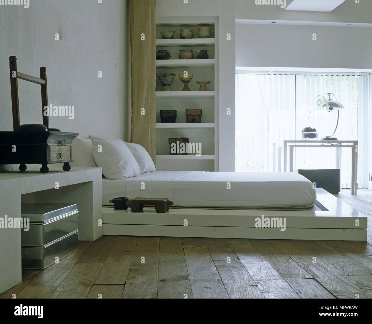 Bed on platform next to display shelving Stock Photo - Alamy