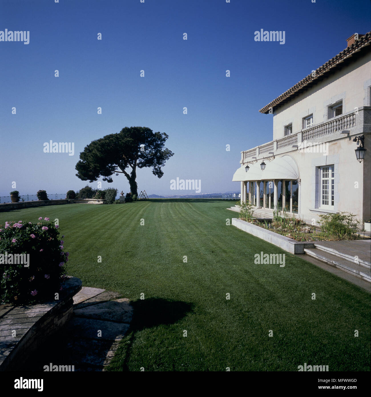 View of a spacious lawn near an eclectic bungalow Stock Photo - Alamy