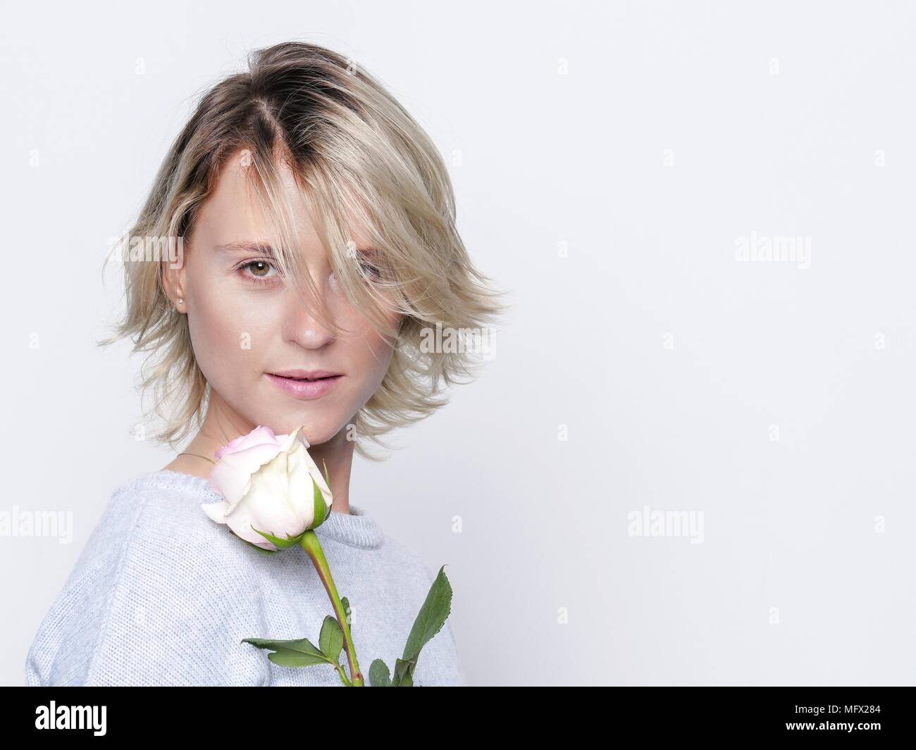 Pink rose in hands of pretty adult woman Stock Photo - Alamy