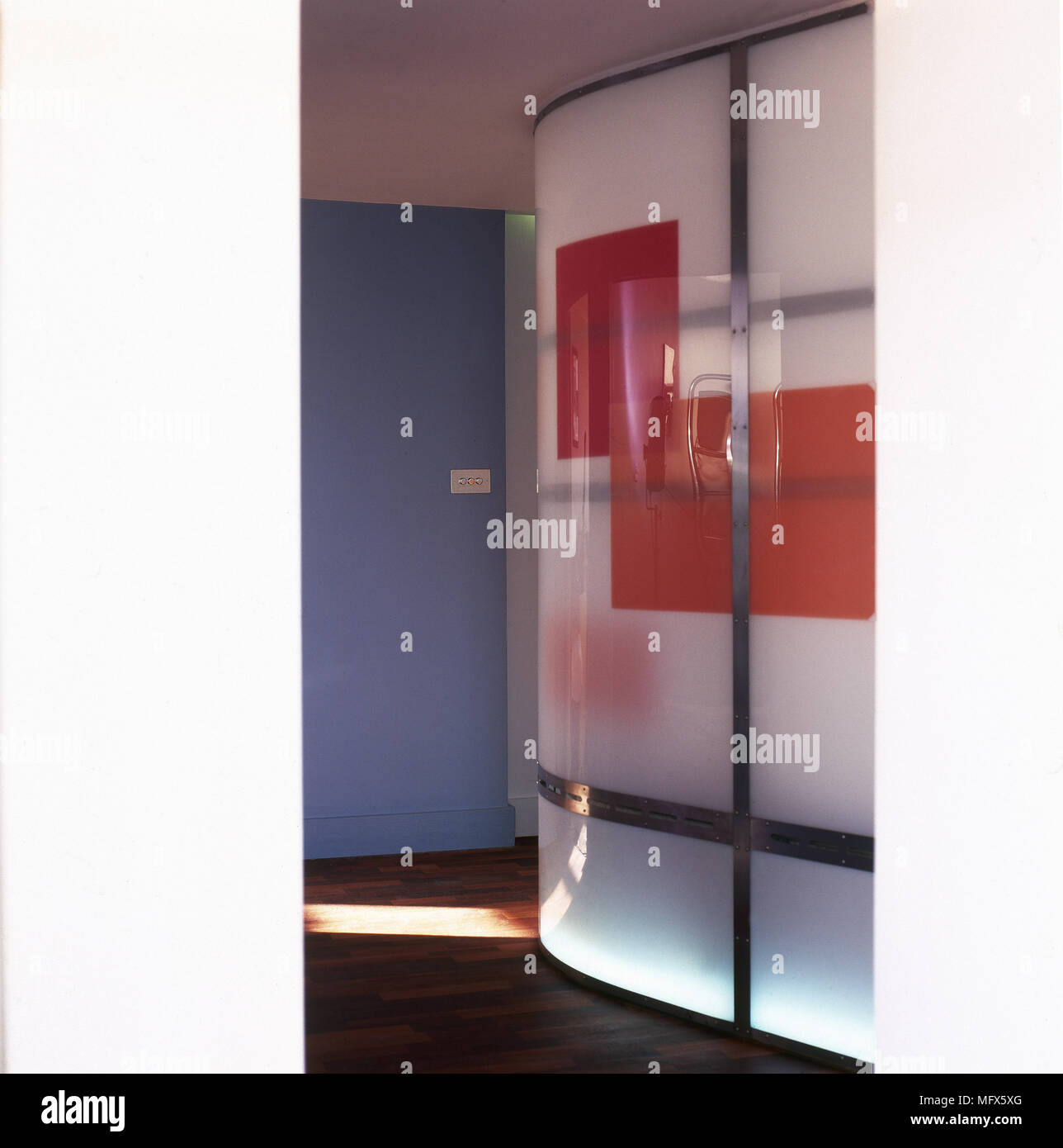 Modern hallway detail with a curving opaque wall featuring a bold ...