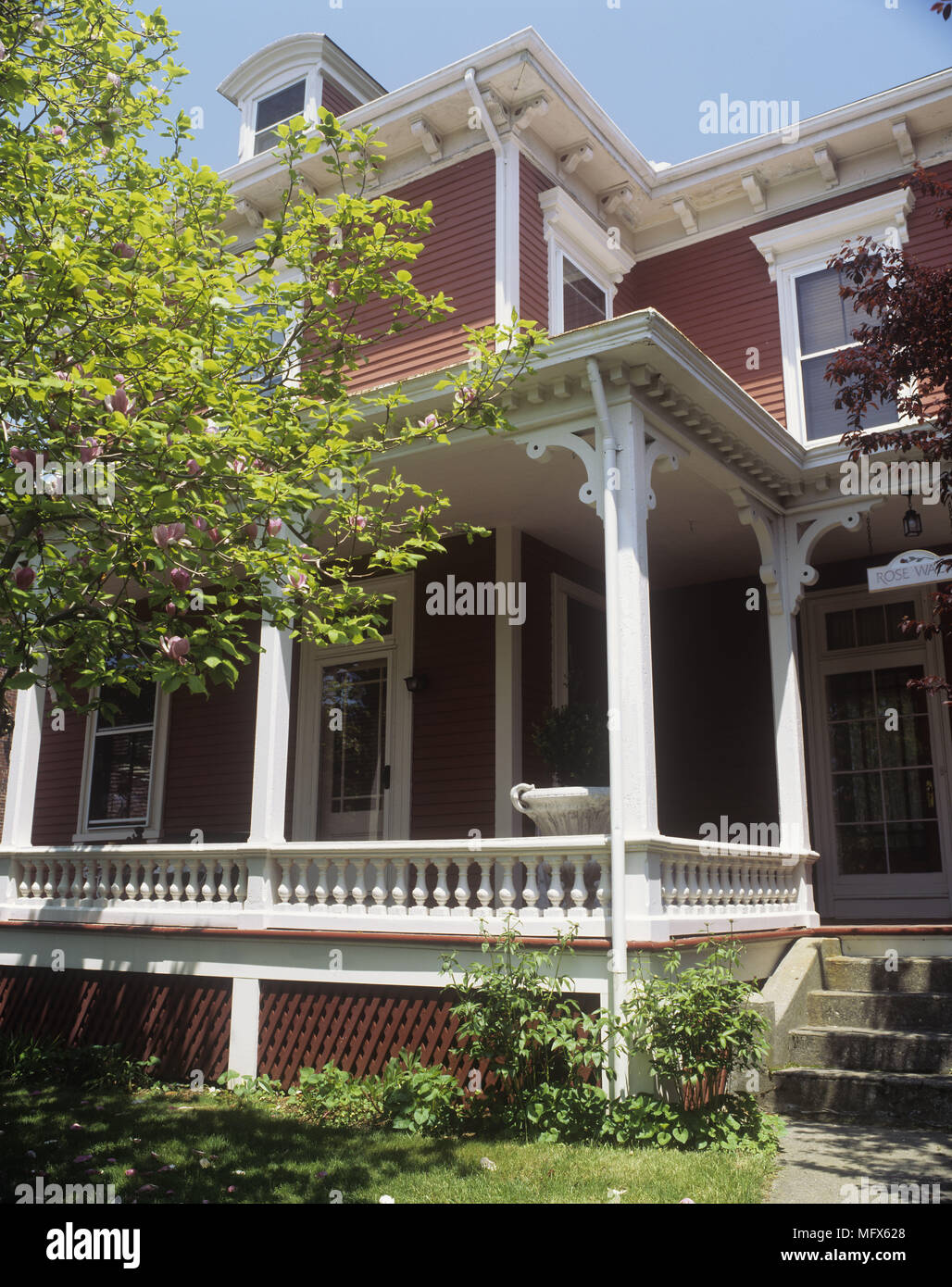 A view of a country colonial style house with white pillars and red ...