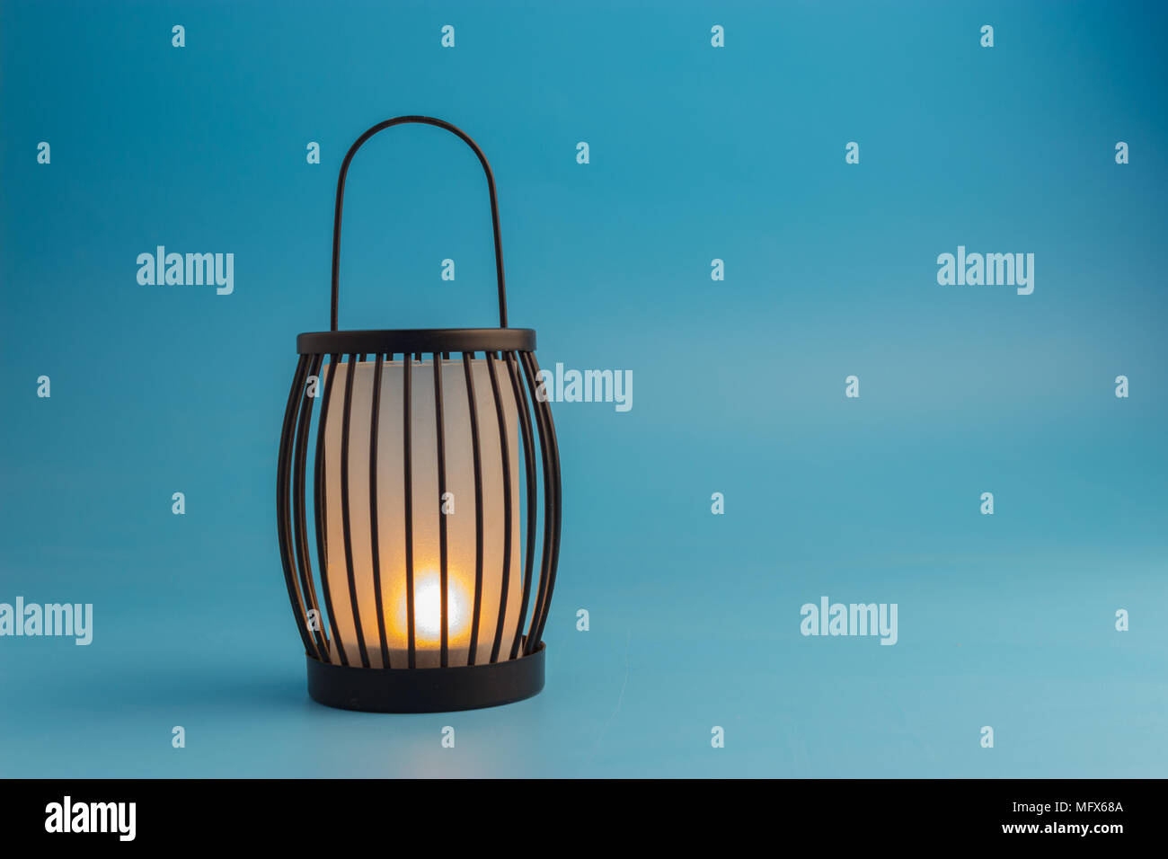 lantern with candle on blue background with copy space Stock Photo - Alamy