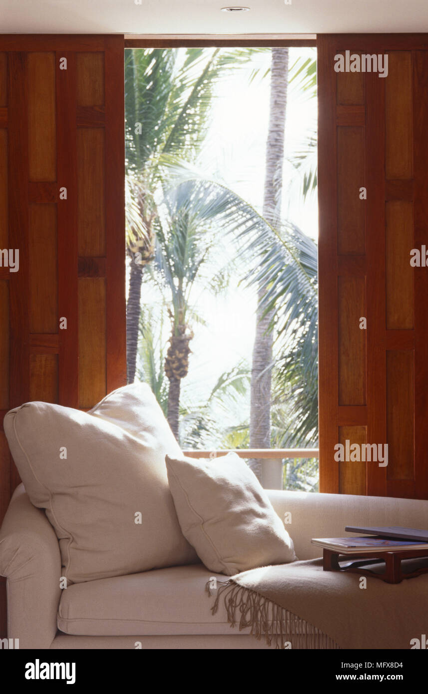 Upholstered sofa in front of window with shutters Stock Photo - Alamy