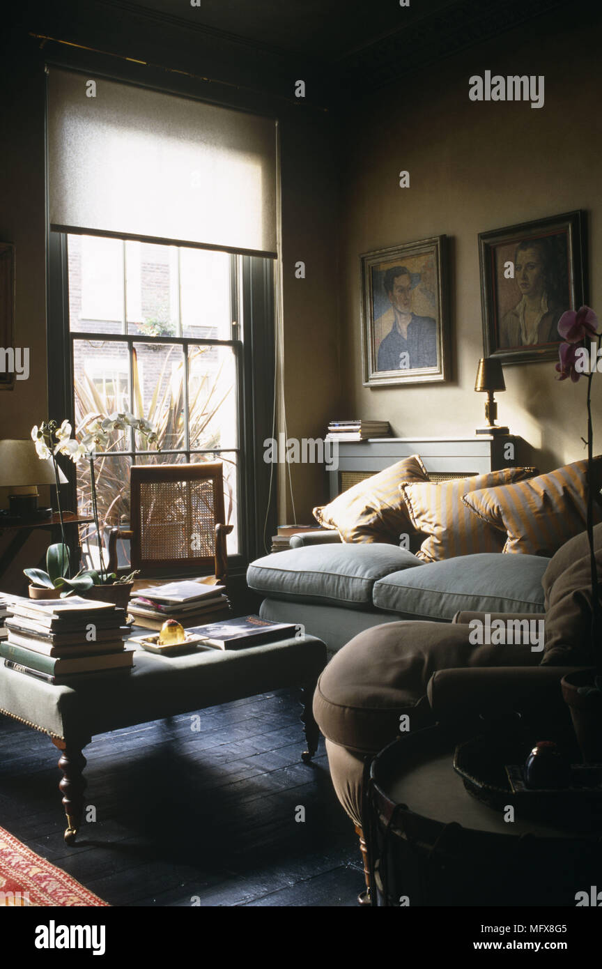Upholstered chairs arranged around ottoman in traditional style room ...