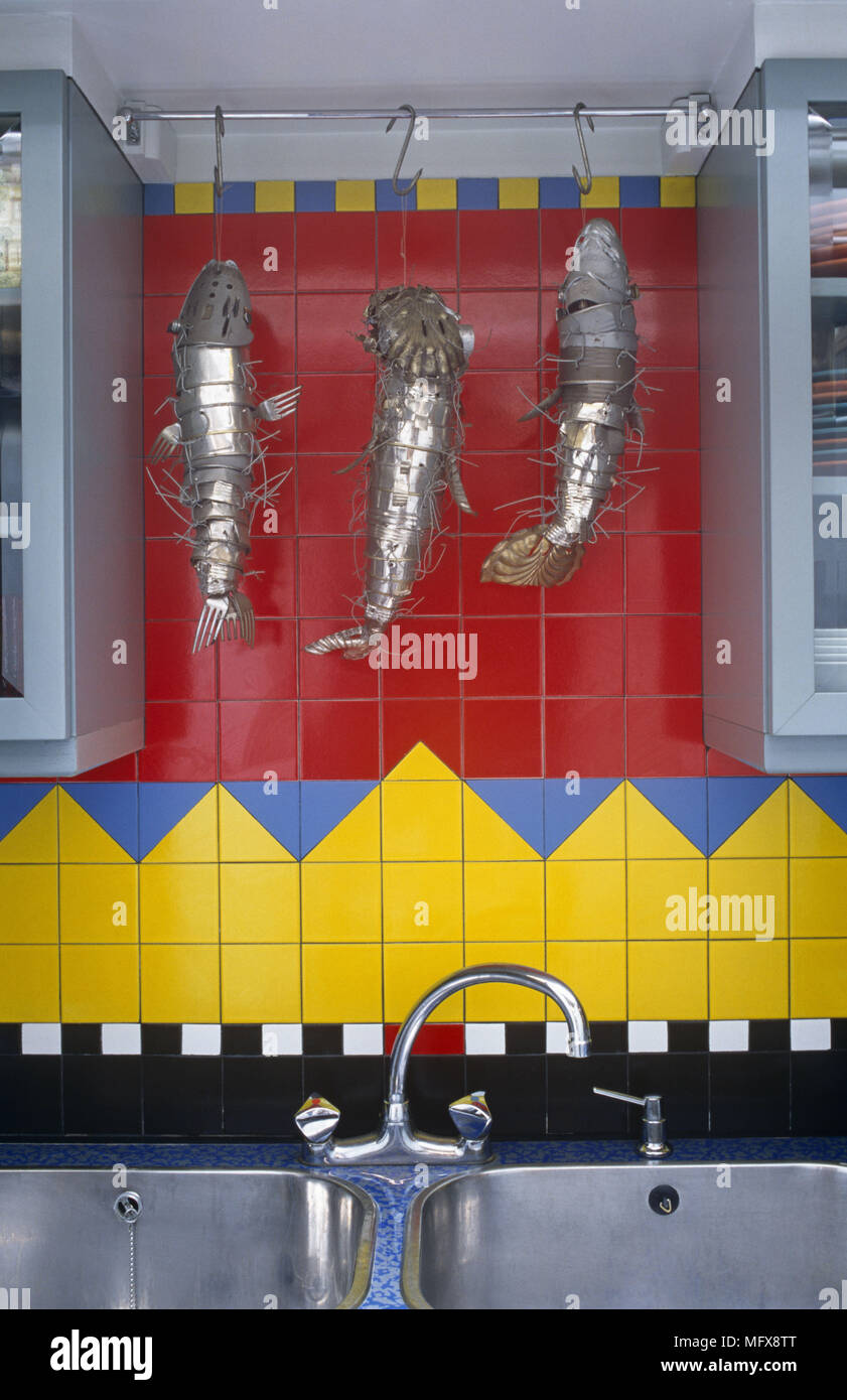 Metal fish figures hanging from hooks above stainless steel kitchen ...