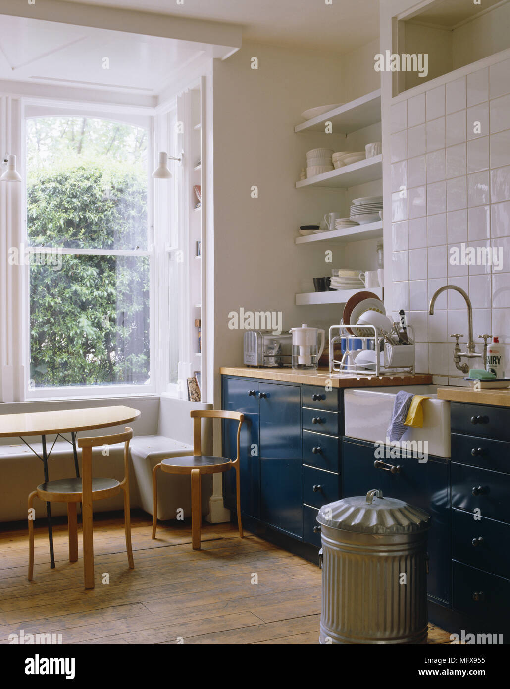 Table and chairs in kitchen with blue units Stock Photo - Alamy