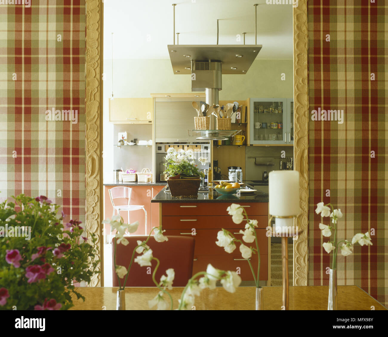 View across dining table to kitchen with wood fitted units Stock Photo ...