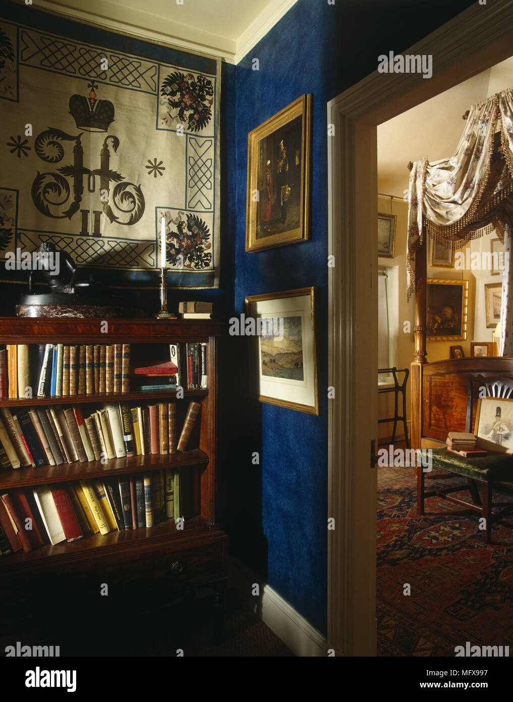 Bookcase in blue home library with view through open door to bedroom ...