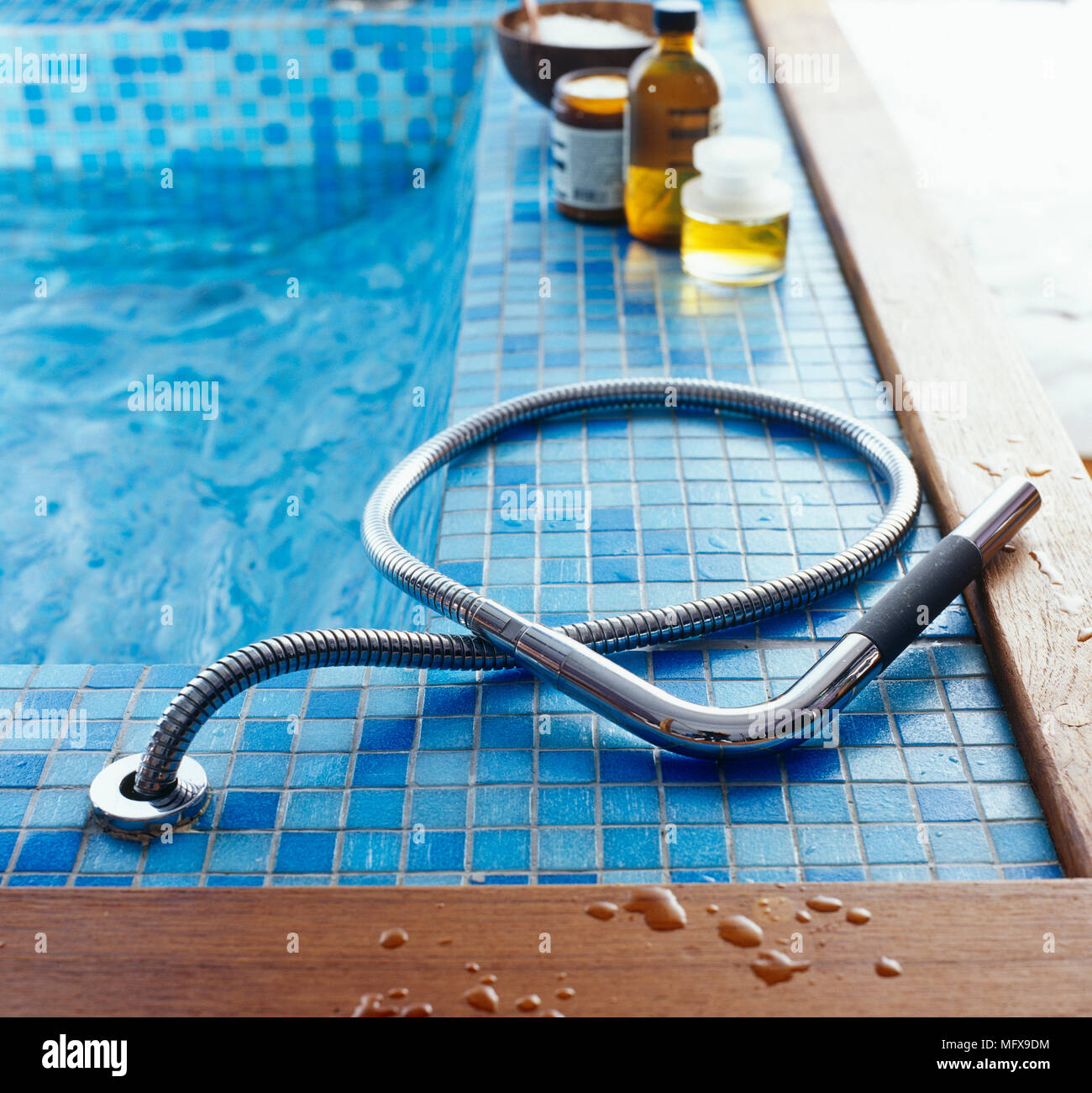 Tap fitting at corner of modern bathtub with blue mosaic tiling Stock ...