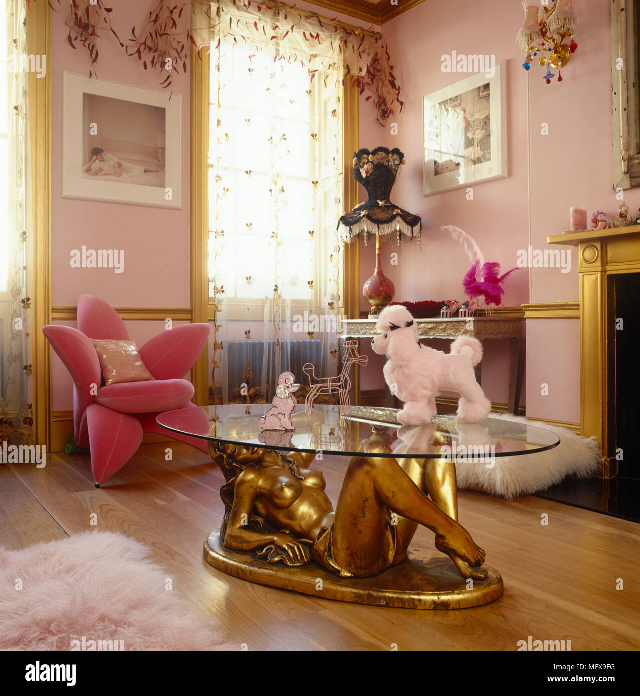 Glass top table with gilt human figure in centre of eclectic sitting ...